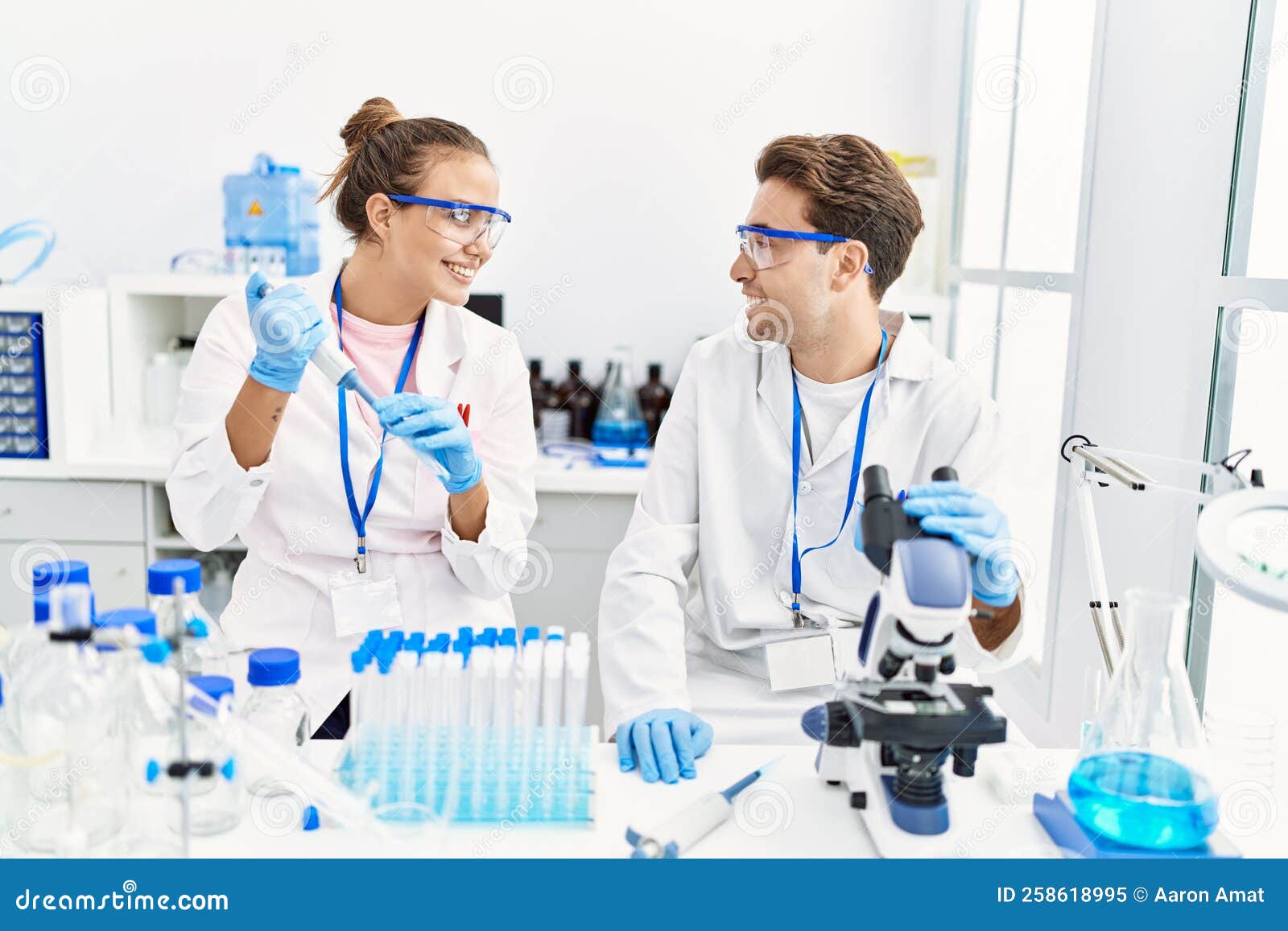 Man and Woman Wearing Scientist Uniform Using Pipette and Microscope ...
