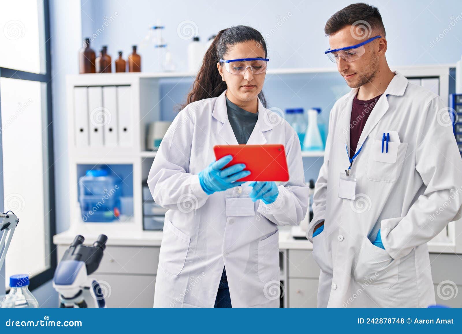 Man and Woman Wearing Scientist Uniform Using Touchpad at Laboratory ...