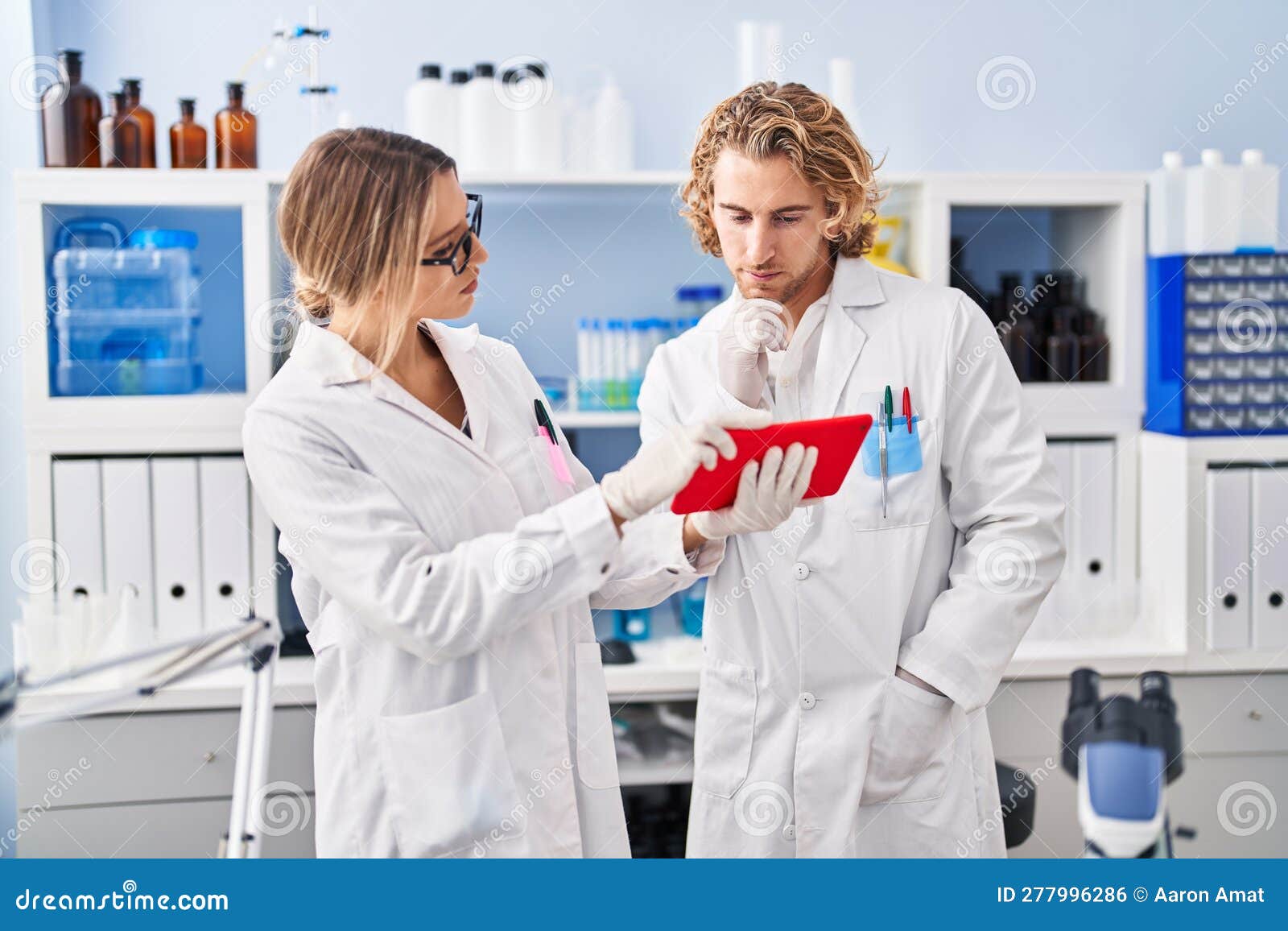 Man and Woman Wearing Scientist Uniform Using Touchpad at Laboratory ...