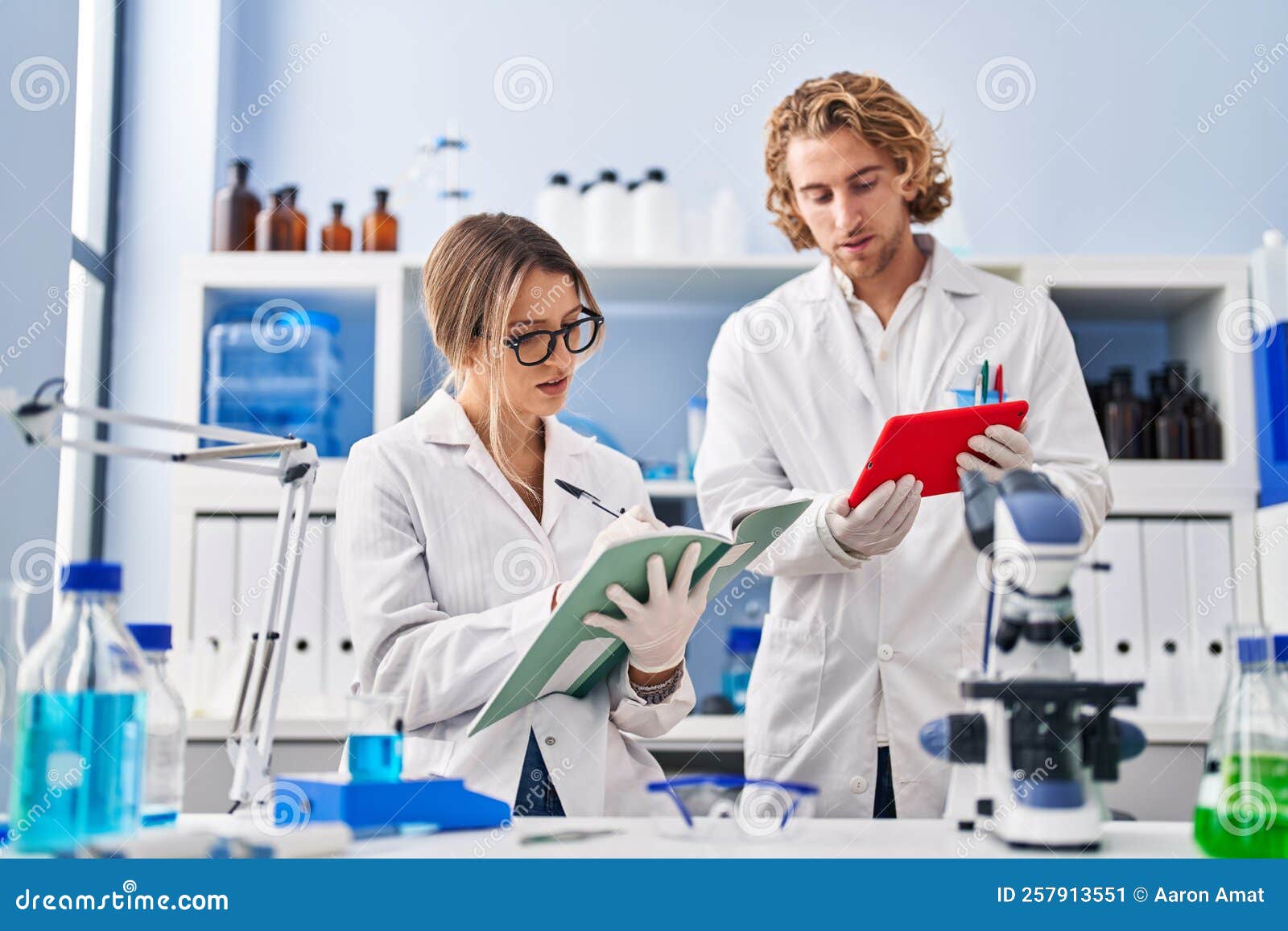Man and Woman Wearing Scientist Uniform Writing on Notebook Using ...