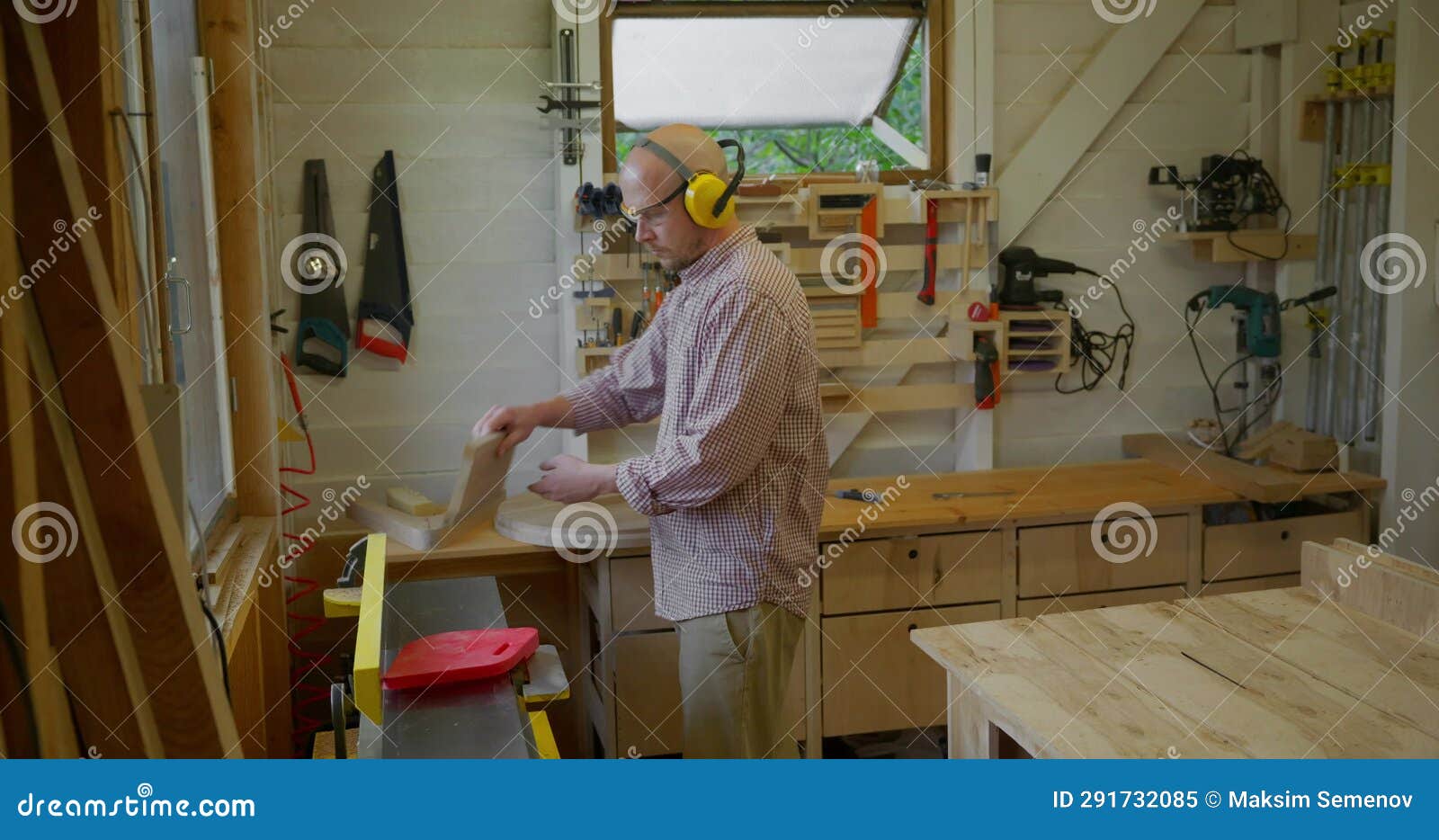 A Man Woodworker Working in His Tiny Workshop on a Jointing Machine ...