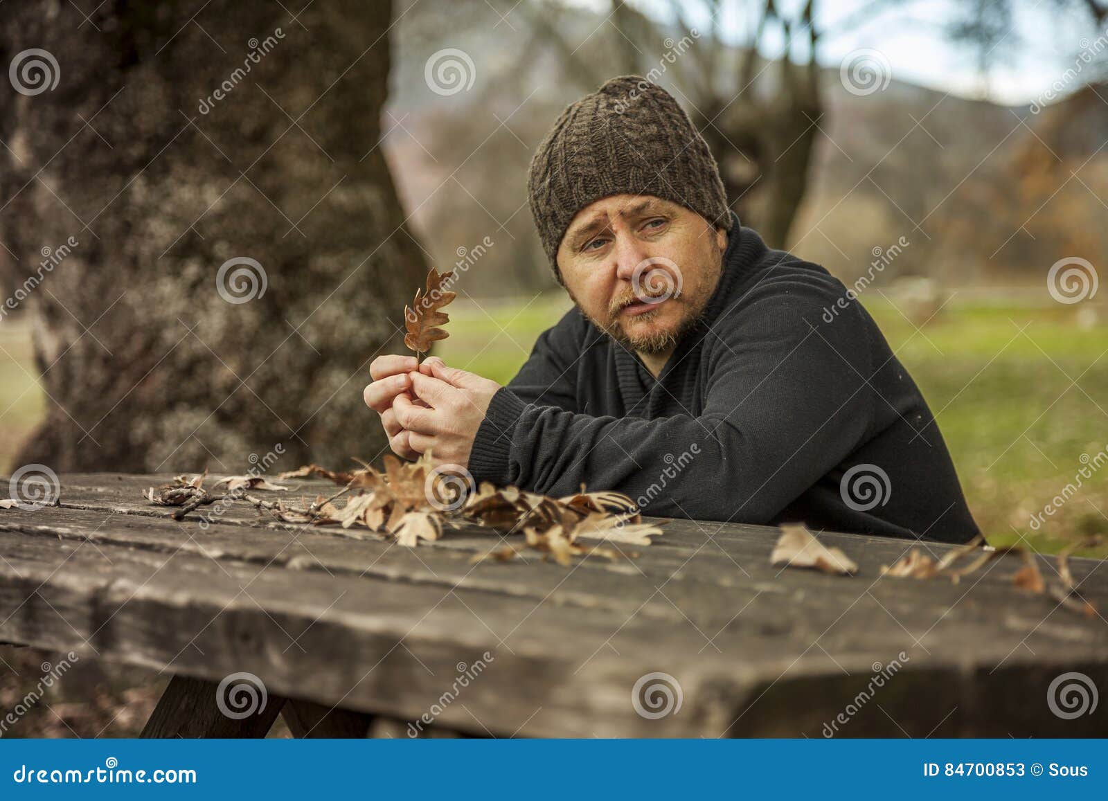 Man with Wool Hat Sitting on the Bench in the Park in Autumn Background ...