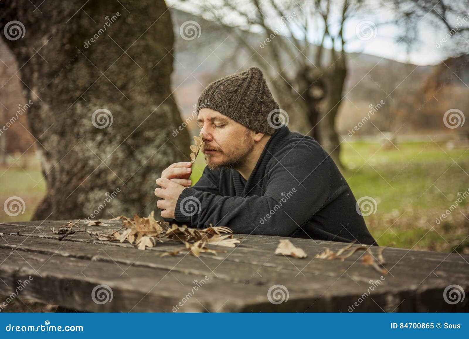 Man with Wool Hat Sitting on the Bench in the Park in Autumn Background ...