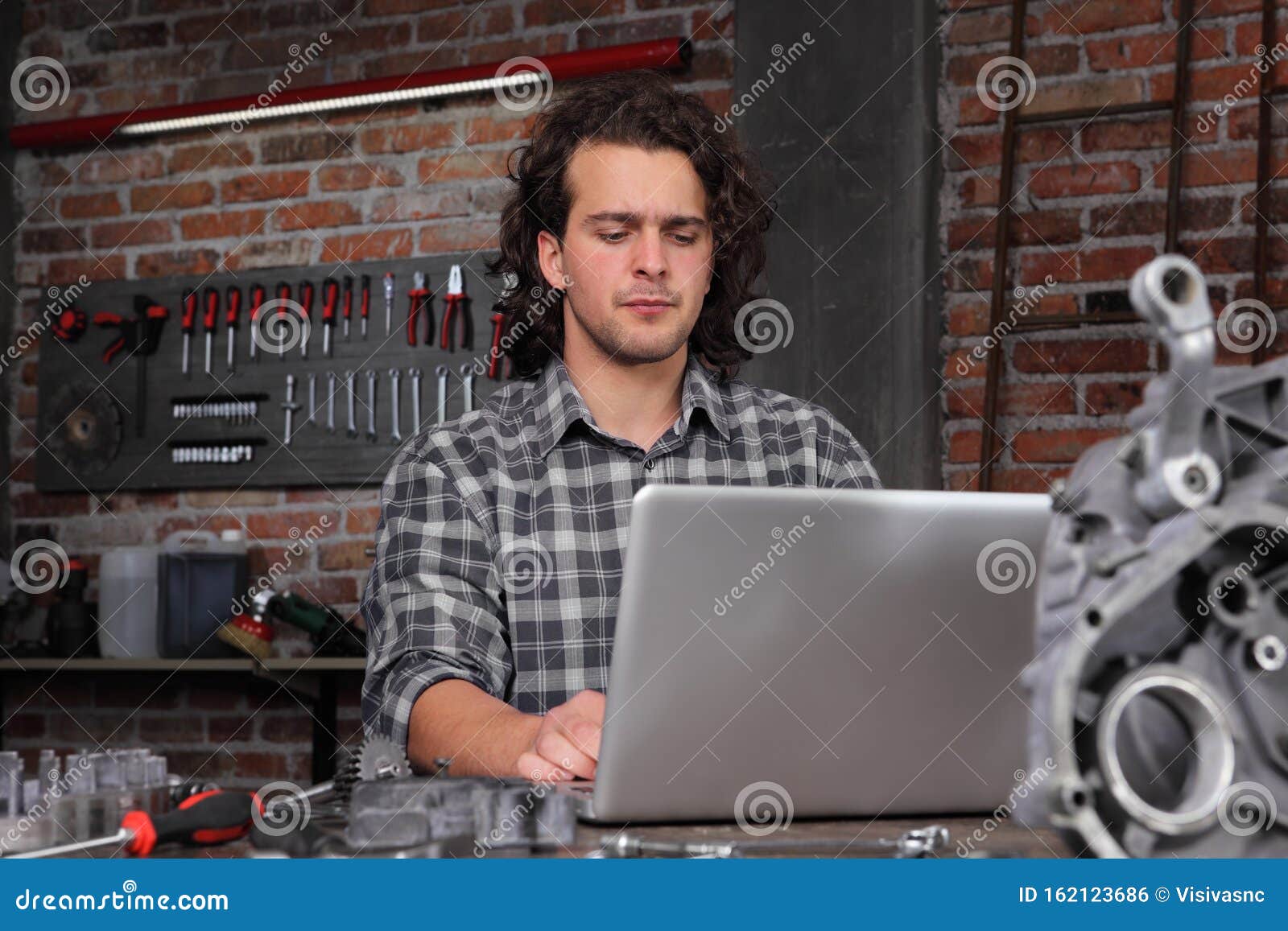 Man Work with Computer Search in Internet Spare Engine Parts on the ...