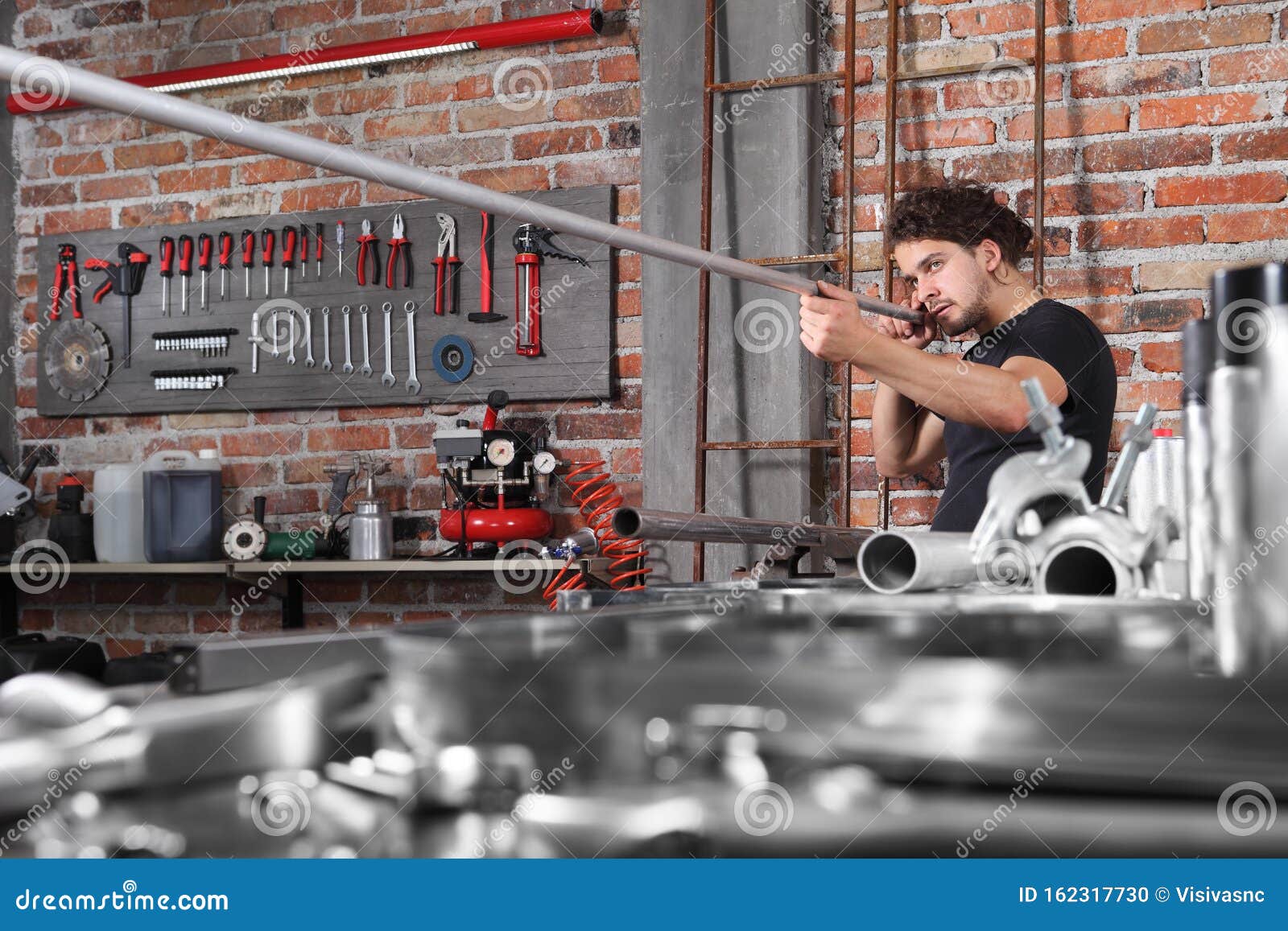 Man Work in Home Workshop Garage Checks the Horizontal Surface of Metal ...