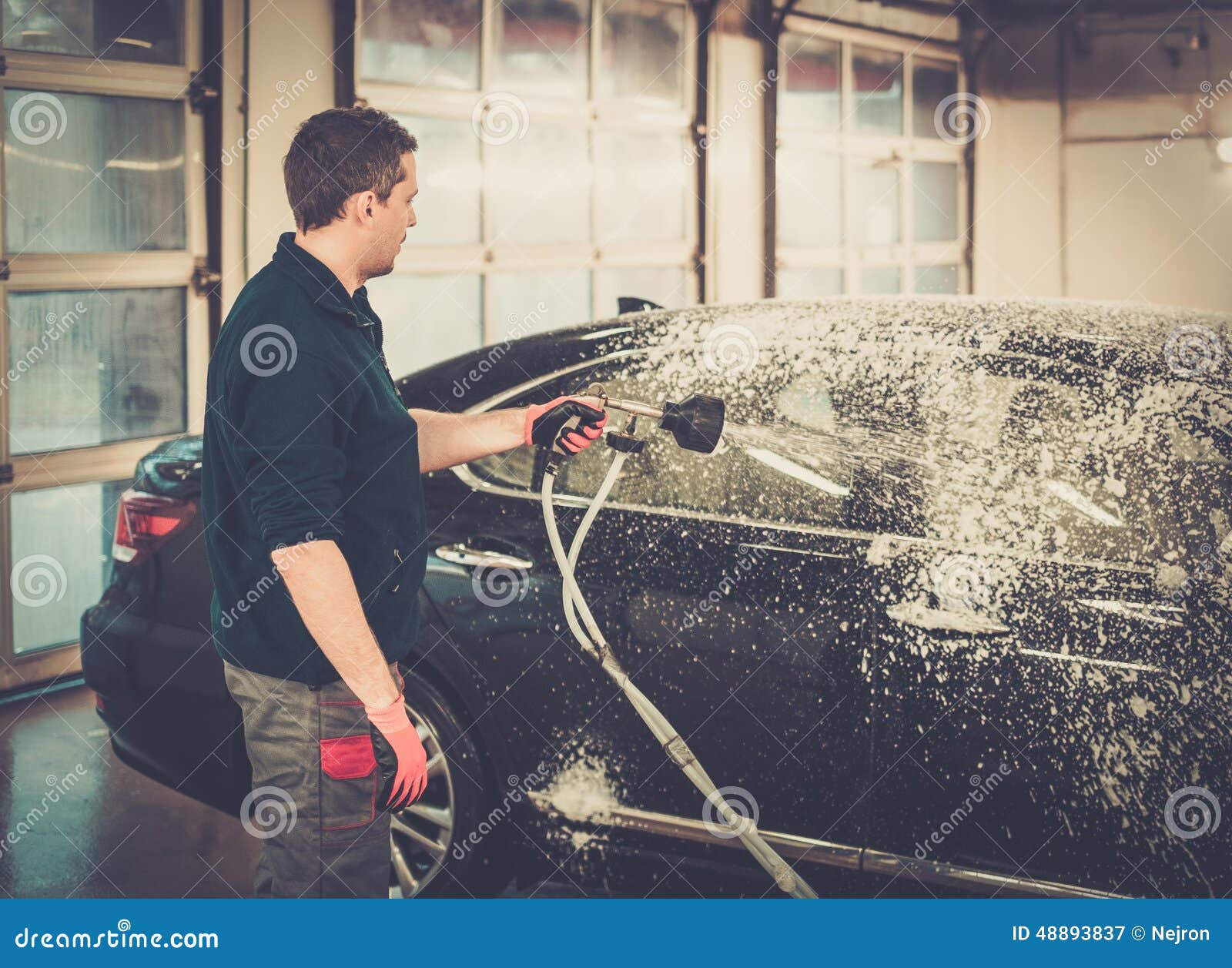 Man worker on a car wash stock image. Image of service - 48893837