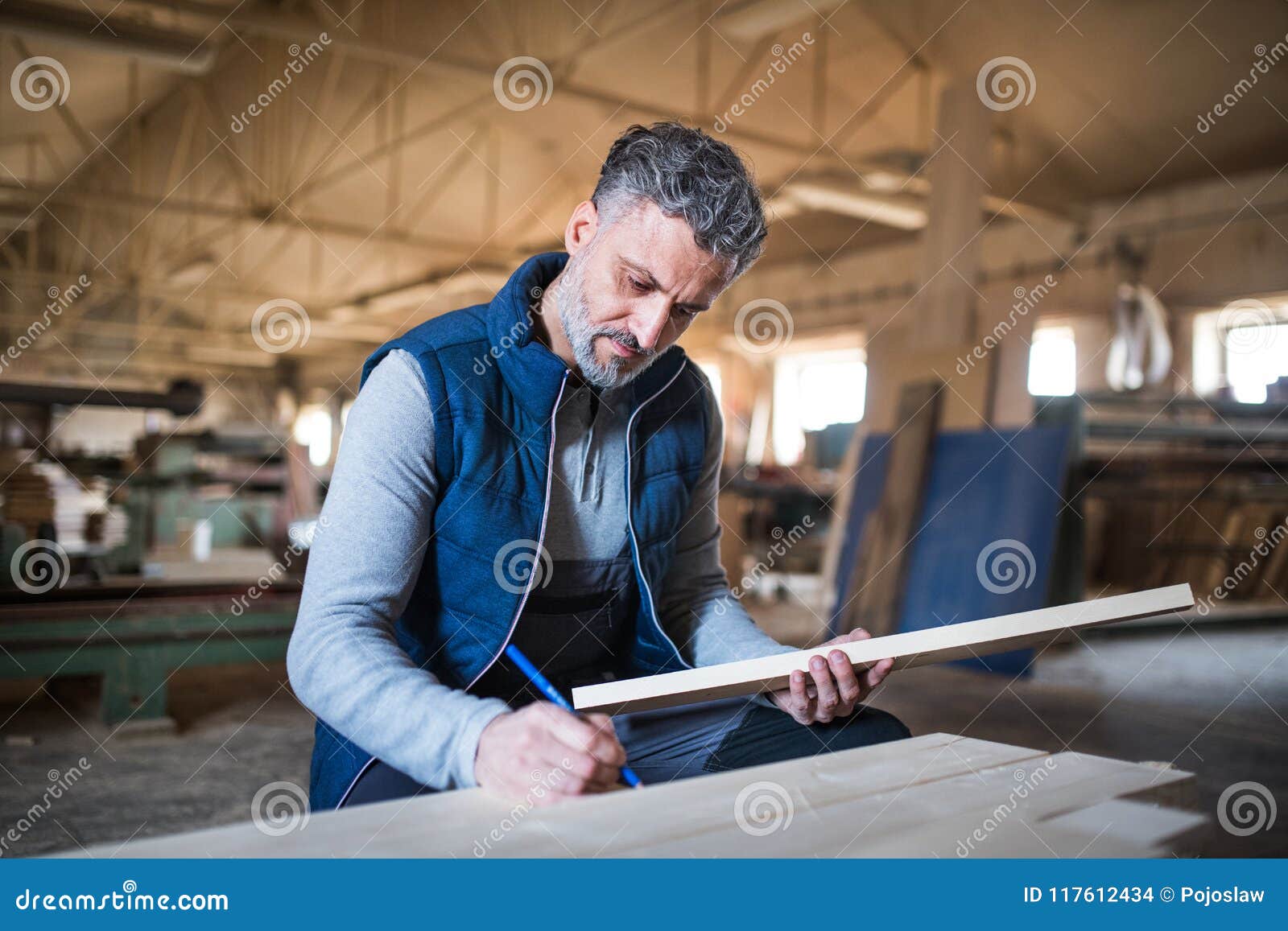 A Man Worker in the Carpentry Workshop, Working with Wood. Stock Photo ...