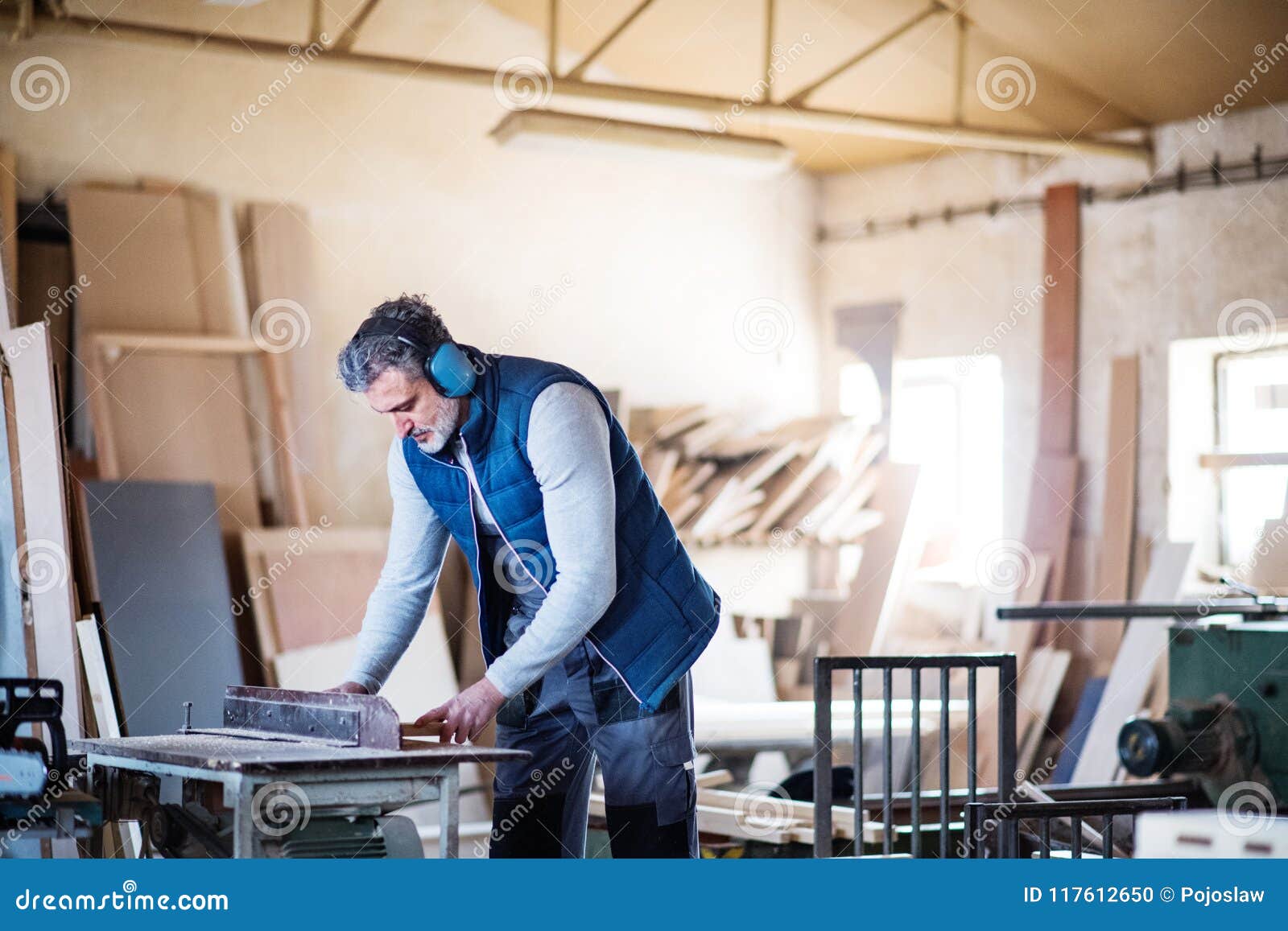 A Man Worker in the Carpentry Workshop, Working with Wood. Stock Photo ...