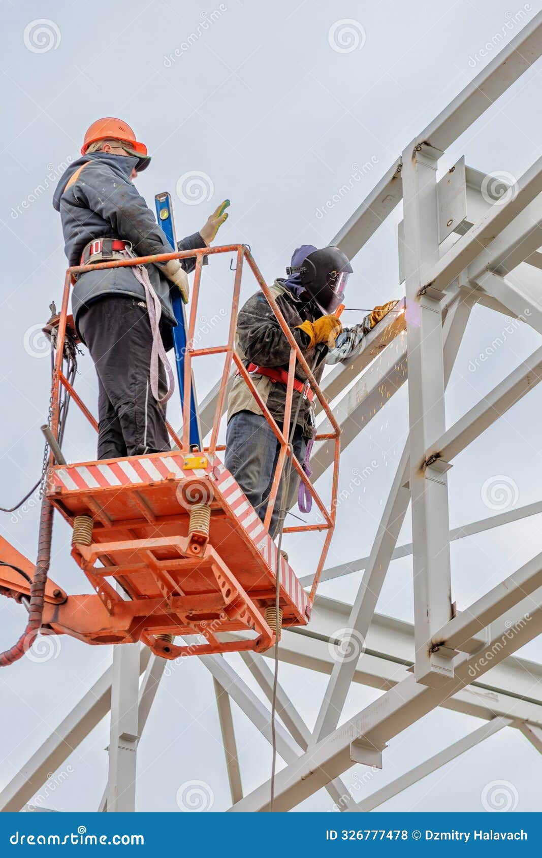 Man Worker on a Crane Performs High-rise Work on Welding Metal ...