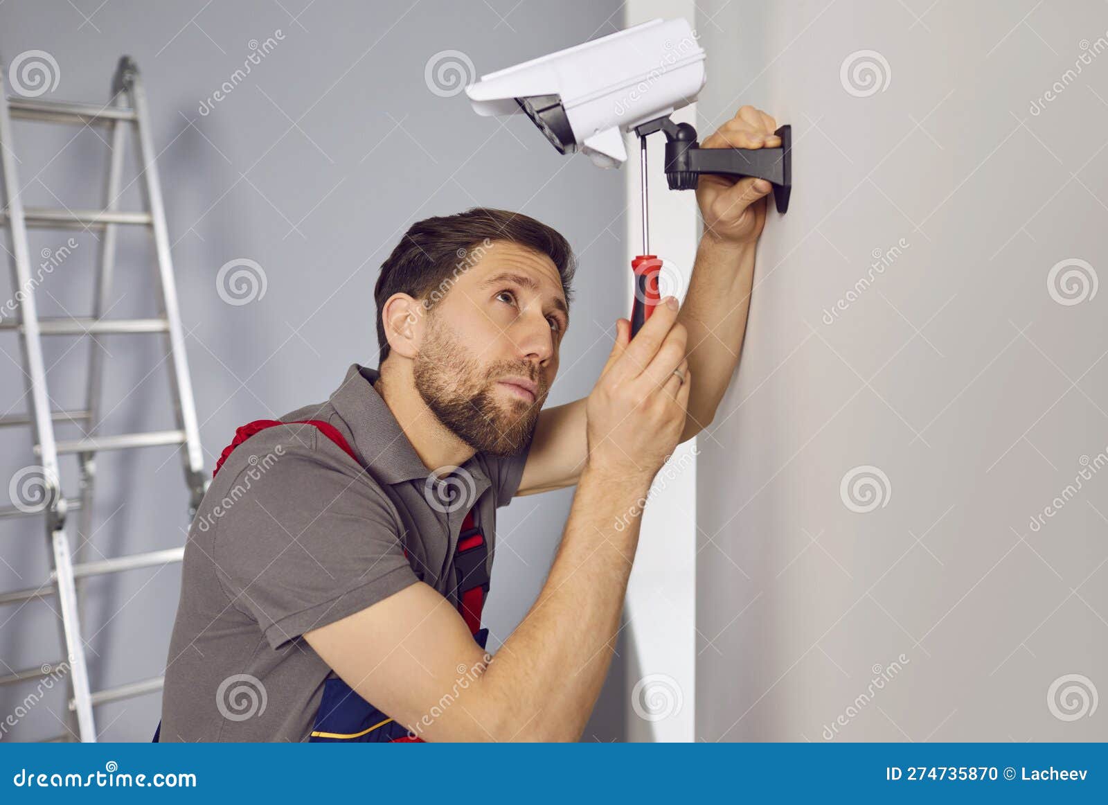 Man Worker Setting Up a Surveillance Camera on the Wall Inside the ...