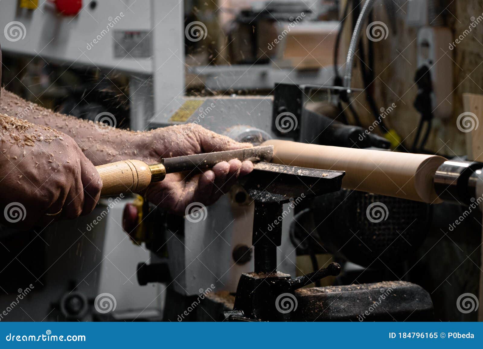 A Man in a Working Apron Works on a Wood Turning Lathe. Stock Image ...