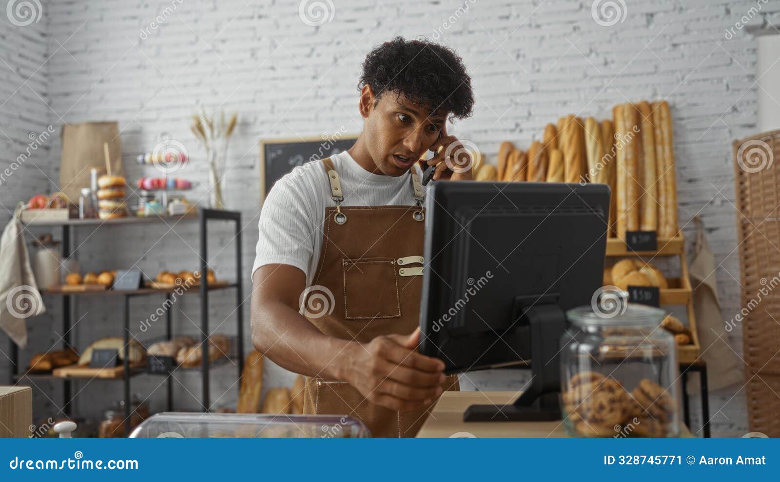 Man Working in a Bakery Attending Customers on the Phone while Using a ...