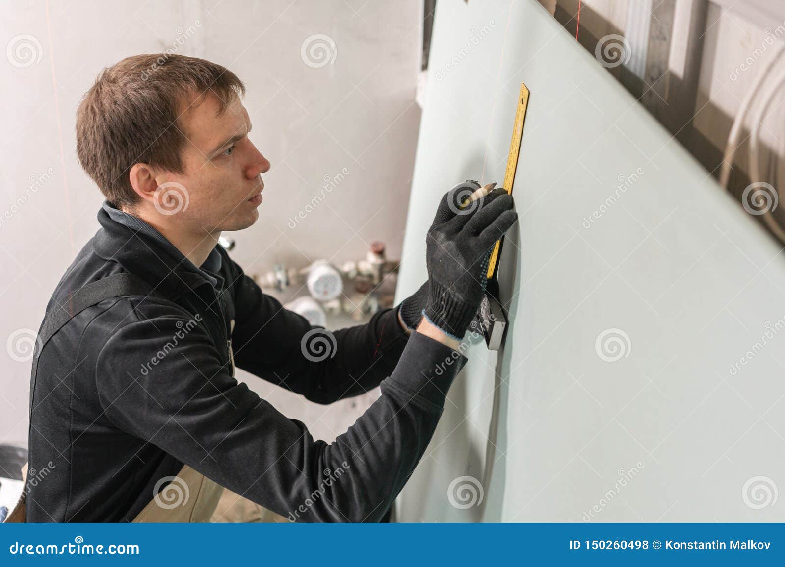 A Man Working Builder Makes a Marking on the Drywall for Electrical ...