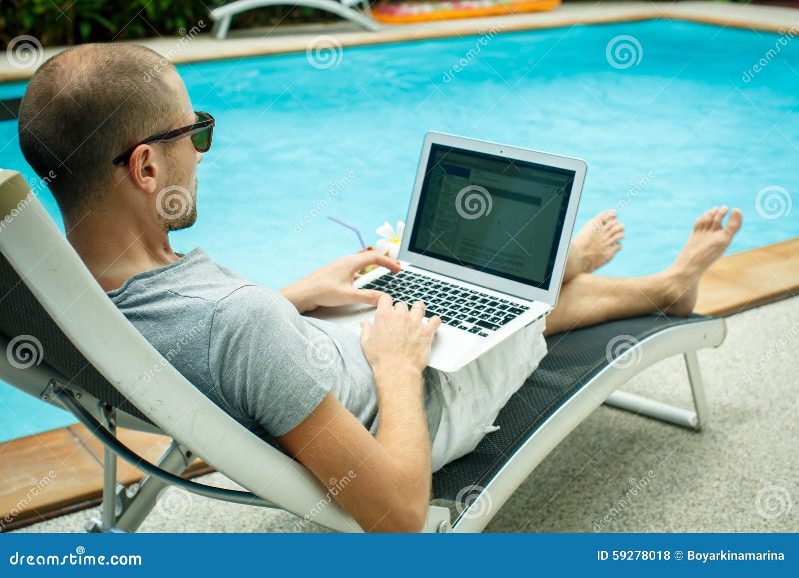 A Man Working at the Computer Next To the Pool Stock Photo - Image of ...