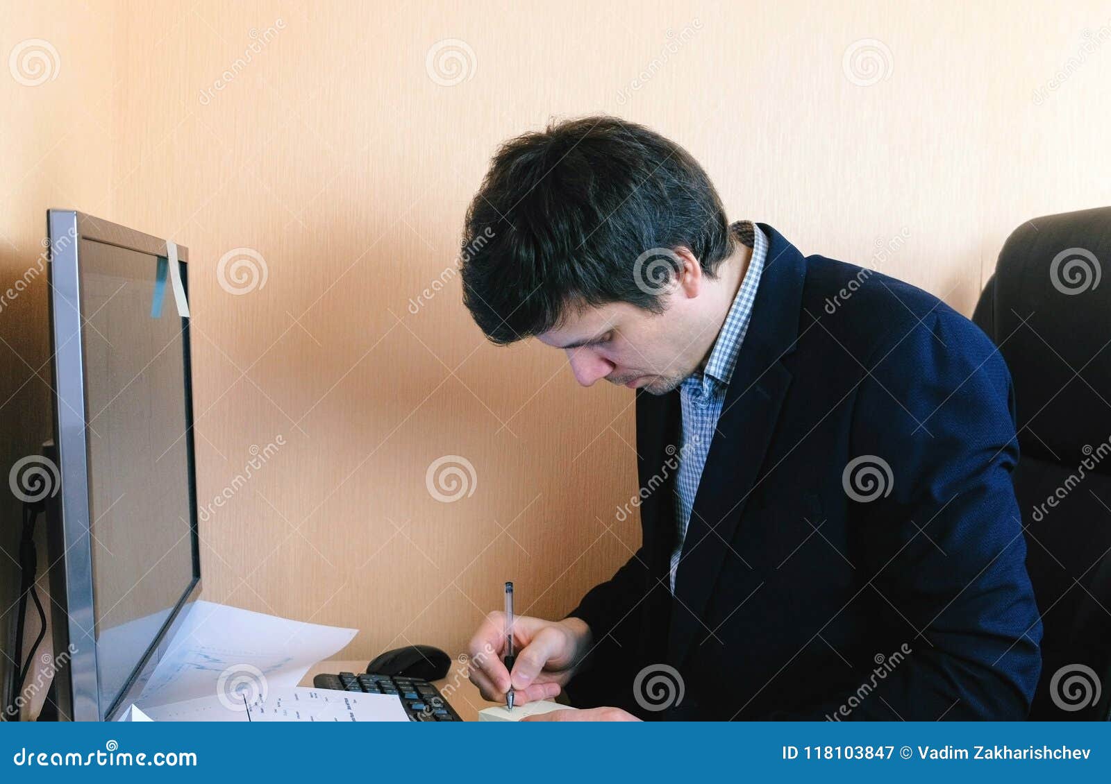 Man Working at the Computer. he Writes Something at Sticker Paper ...