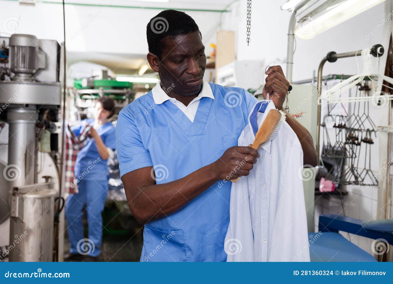 Man working in dry cleaner stock photo. Image of adult - 281360324