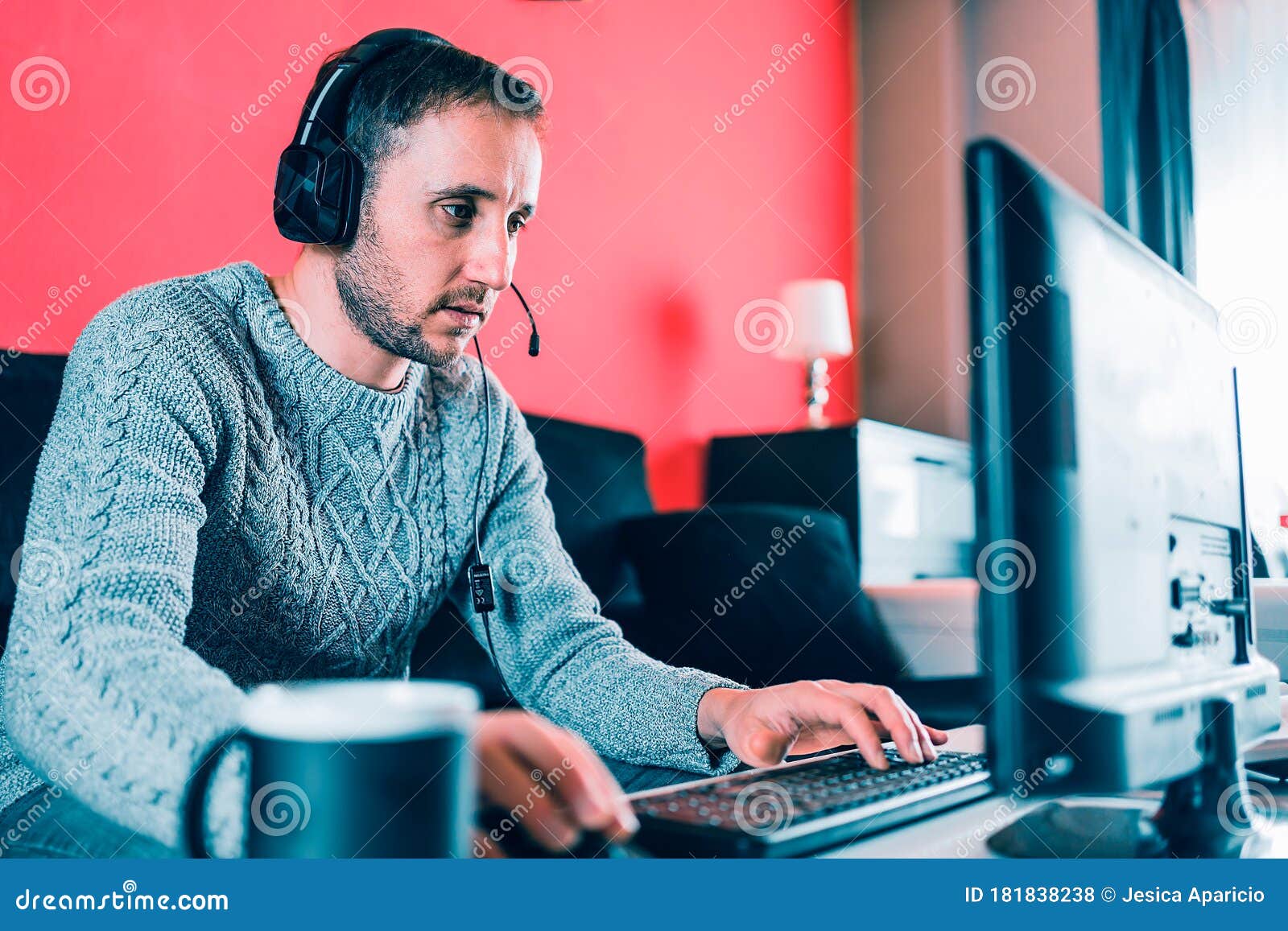 Man Working from His Couch at Home with a Computer, Headphones. Stock ...