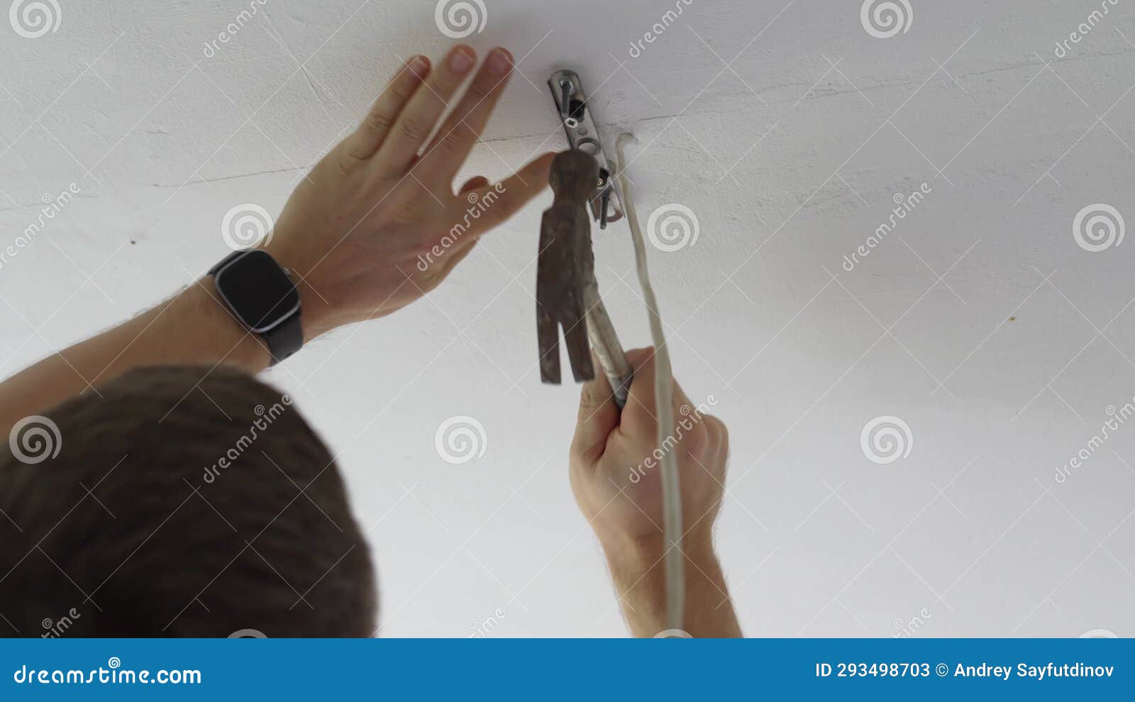A Man is Working on the Installation of a Ceiling Luminaire on the ...