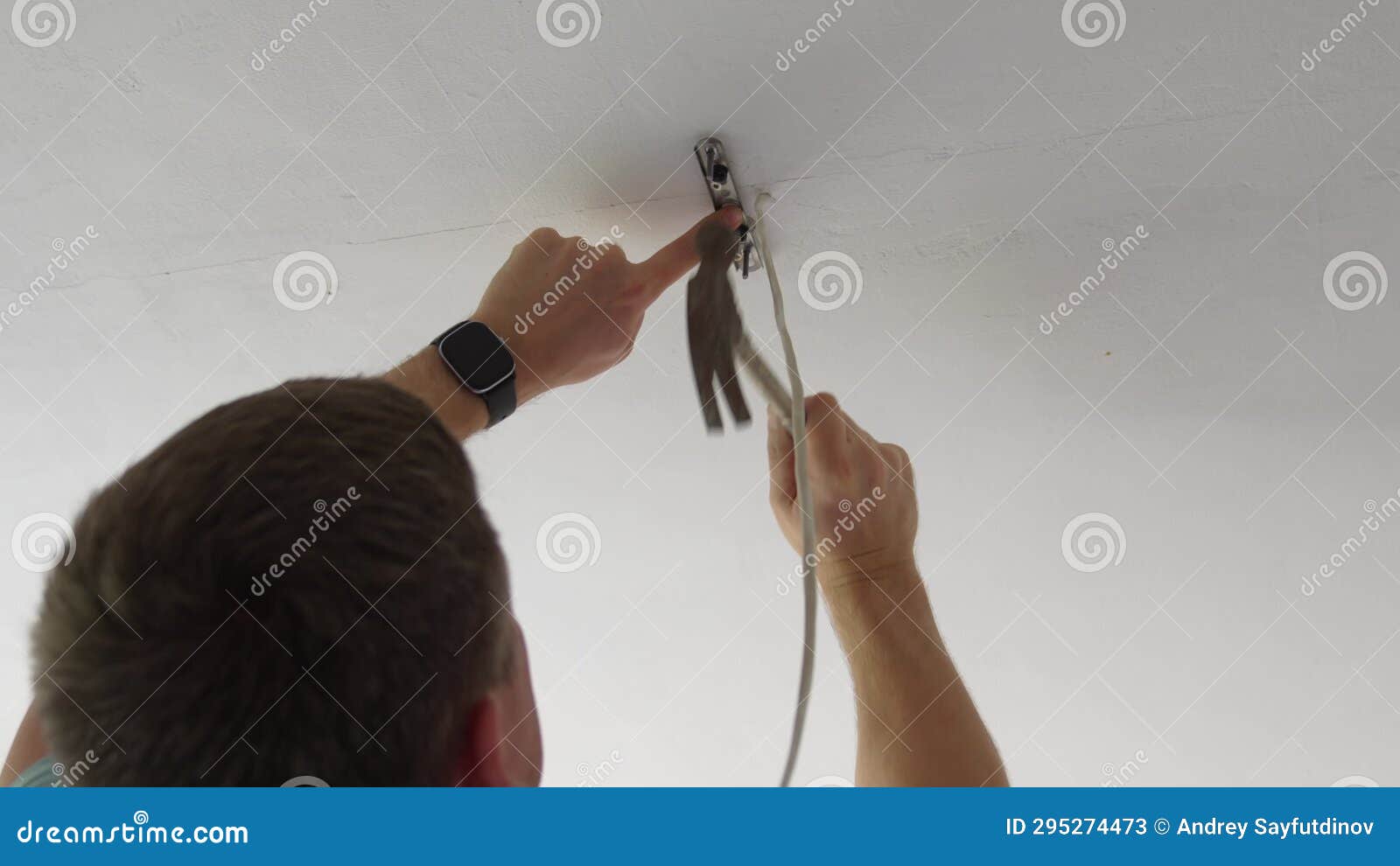 A Man is Working on the Installation of a Ceiling Luminaire on the ...
