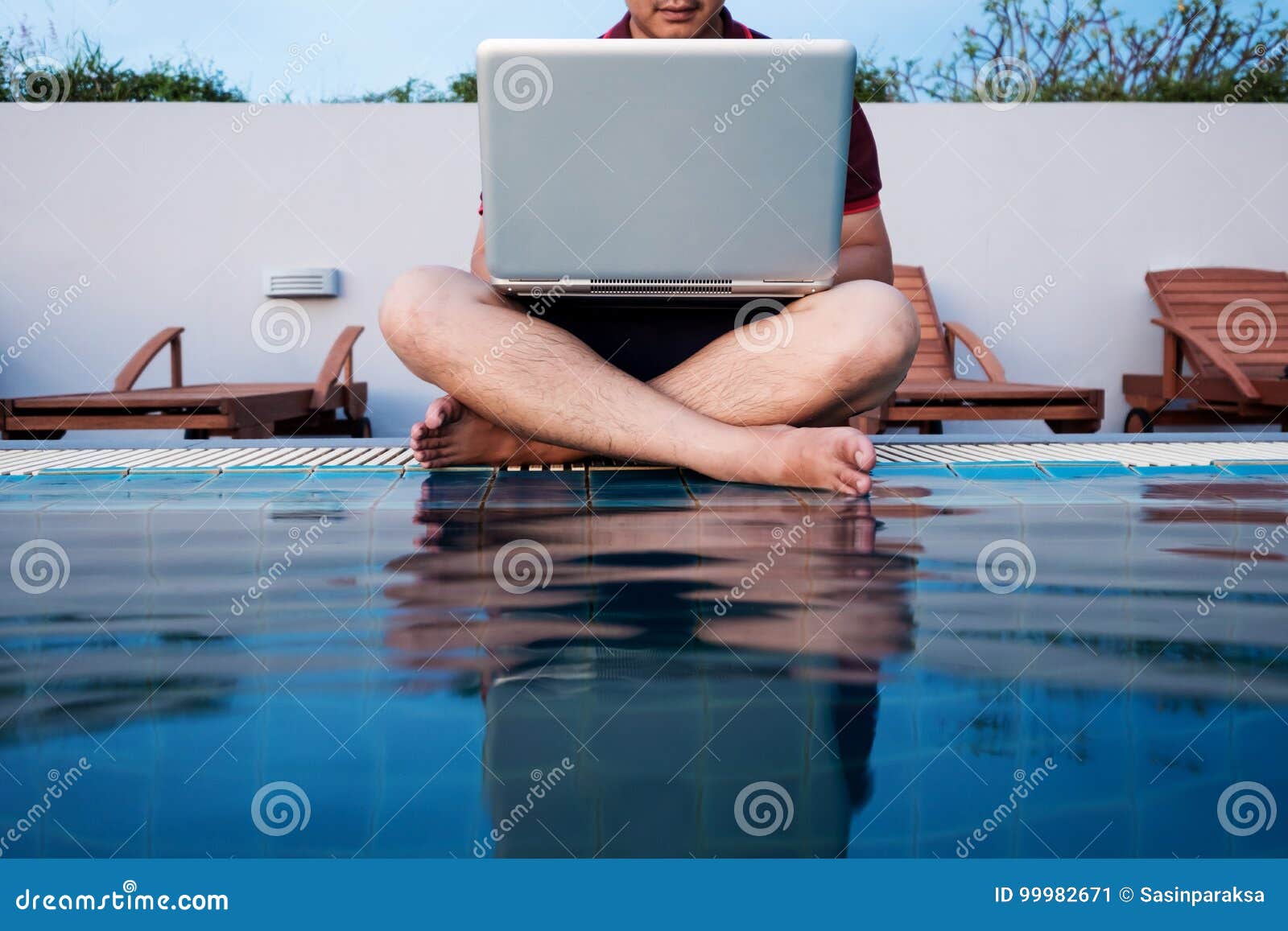 A Man Working on Laptop Computer, Sitting at Poolside, Selective Focus ...