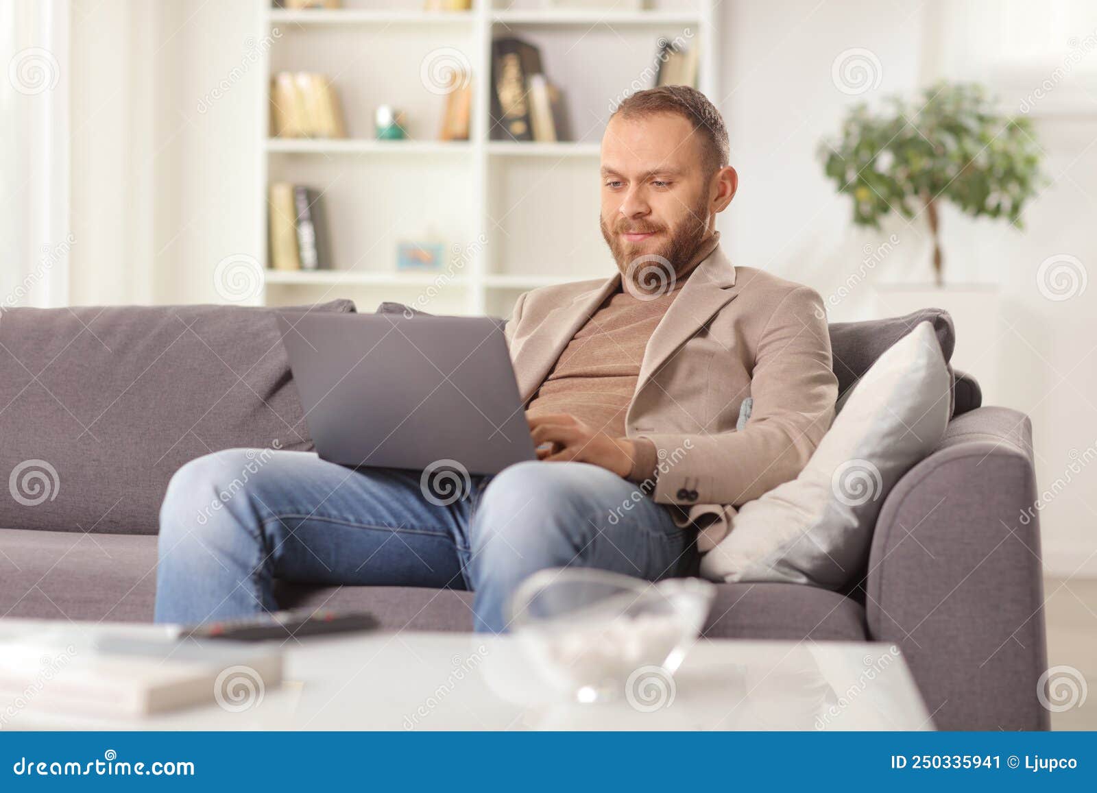 Man Working on a Laptop Computer and Sitting on a Sofa Stock Image ...