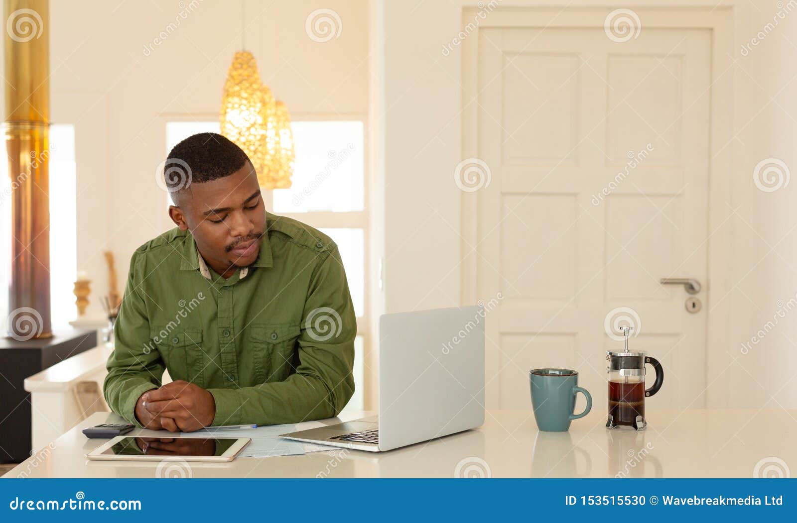 Man Working on Laptop at Dining Table in Kitchen at Comfortable Home ...