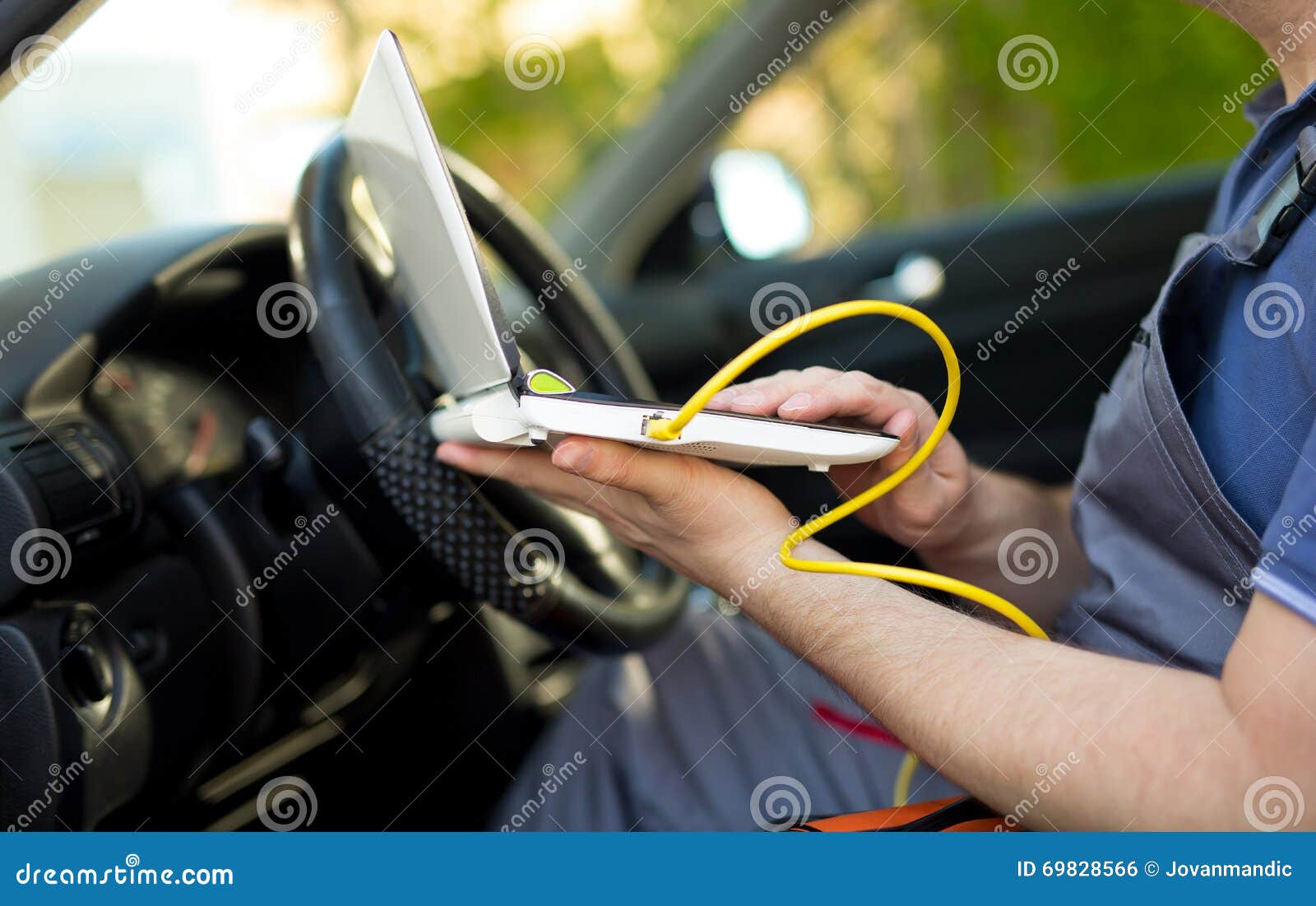 Man Working on Laptop while Sitting in a Car in Workshop Stock Photo ...