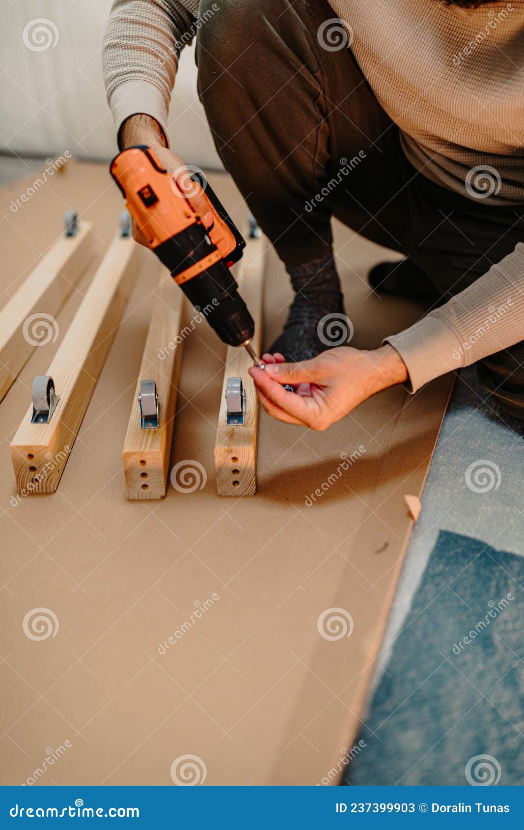 A Man Working on a New Bed Installation and Using a Cordless Drill ...