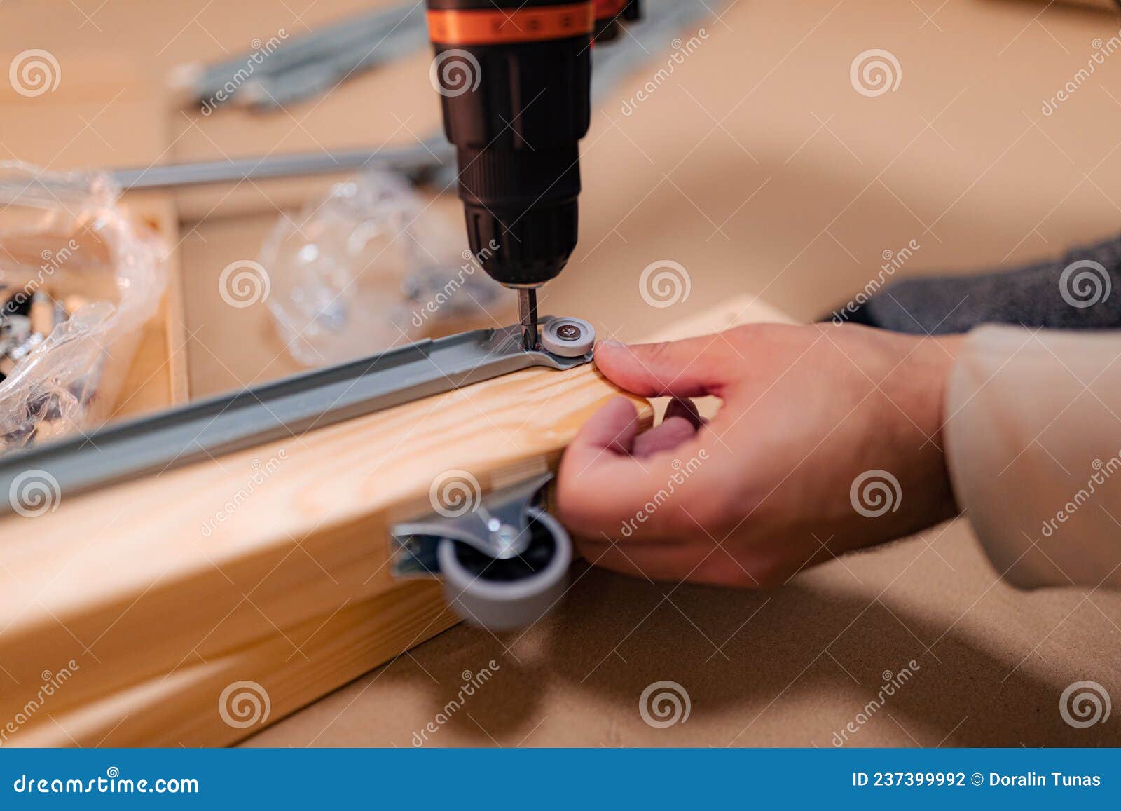 A Man Working on a New Bed Installation and Using a Cordless Drill ...