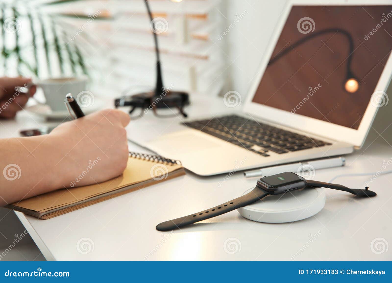 Man Working at Table while Smartwatch Charging with Wireless Device ...