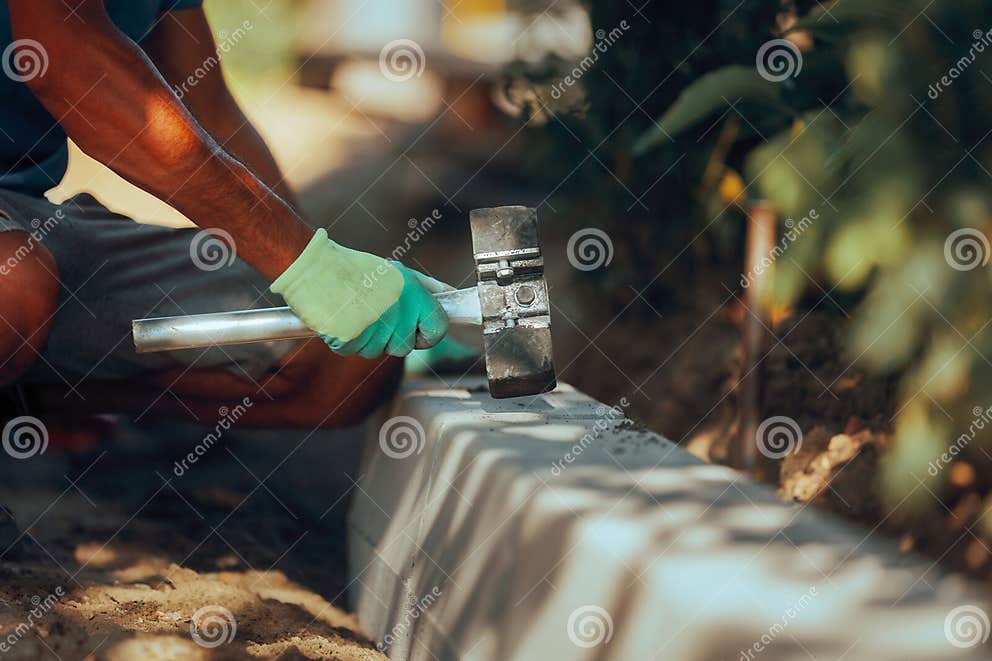 Construction Worker Using a Hammer for Fixing New Curb Blocks Stock ...