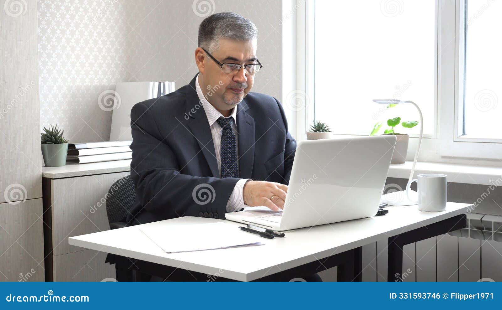 A Man Works on a Computer. he Looks at the Screen and Types on the ...