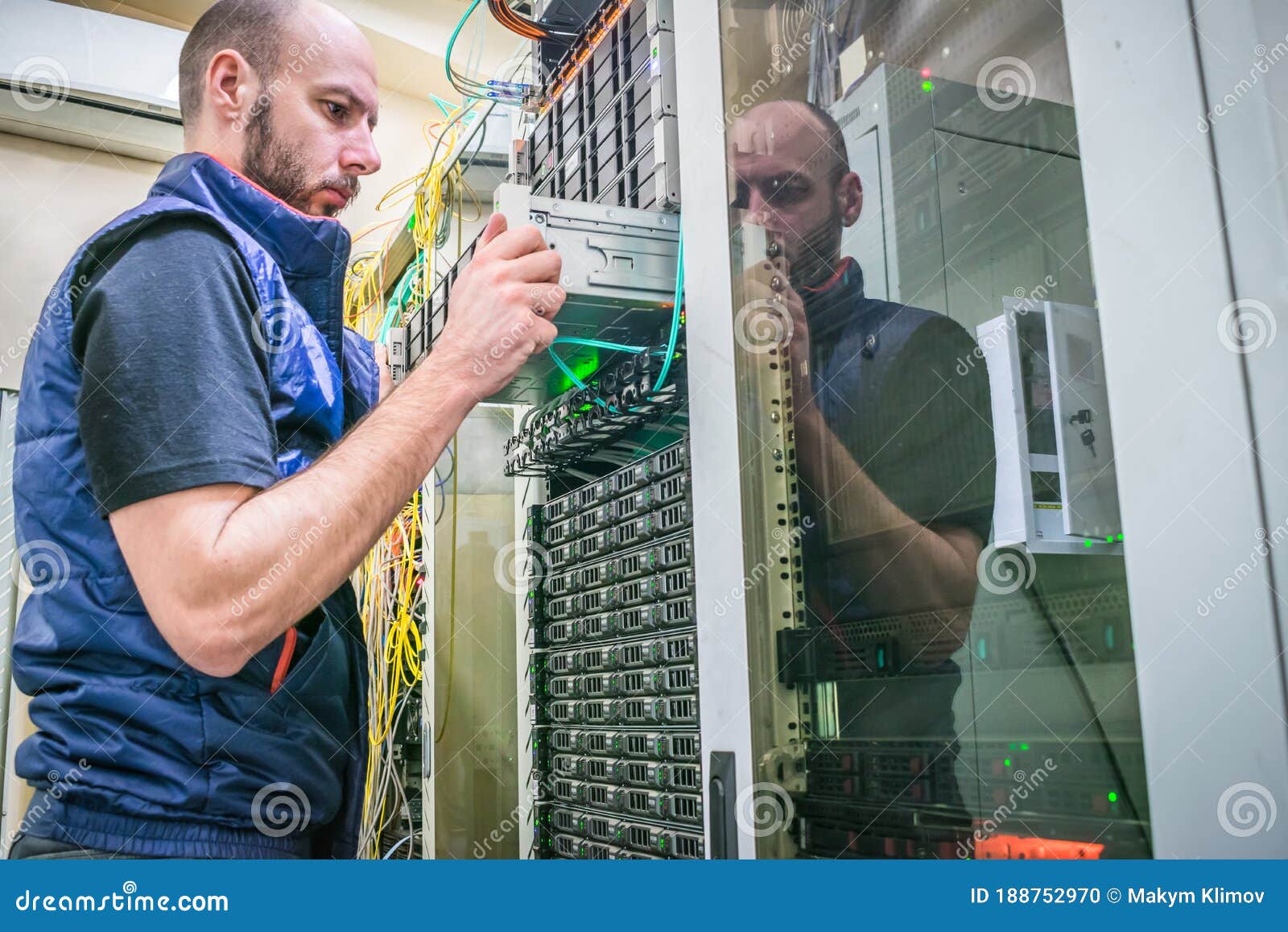 A Man Works in a Server Room. Technician Repairs the Central Router ...