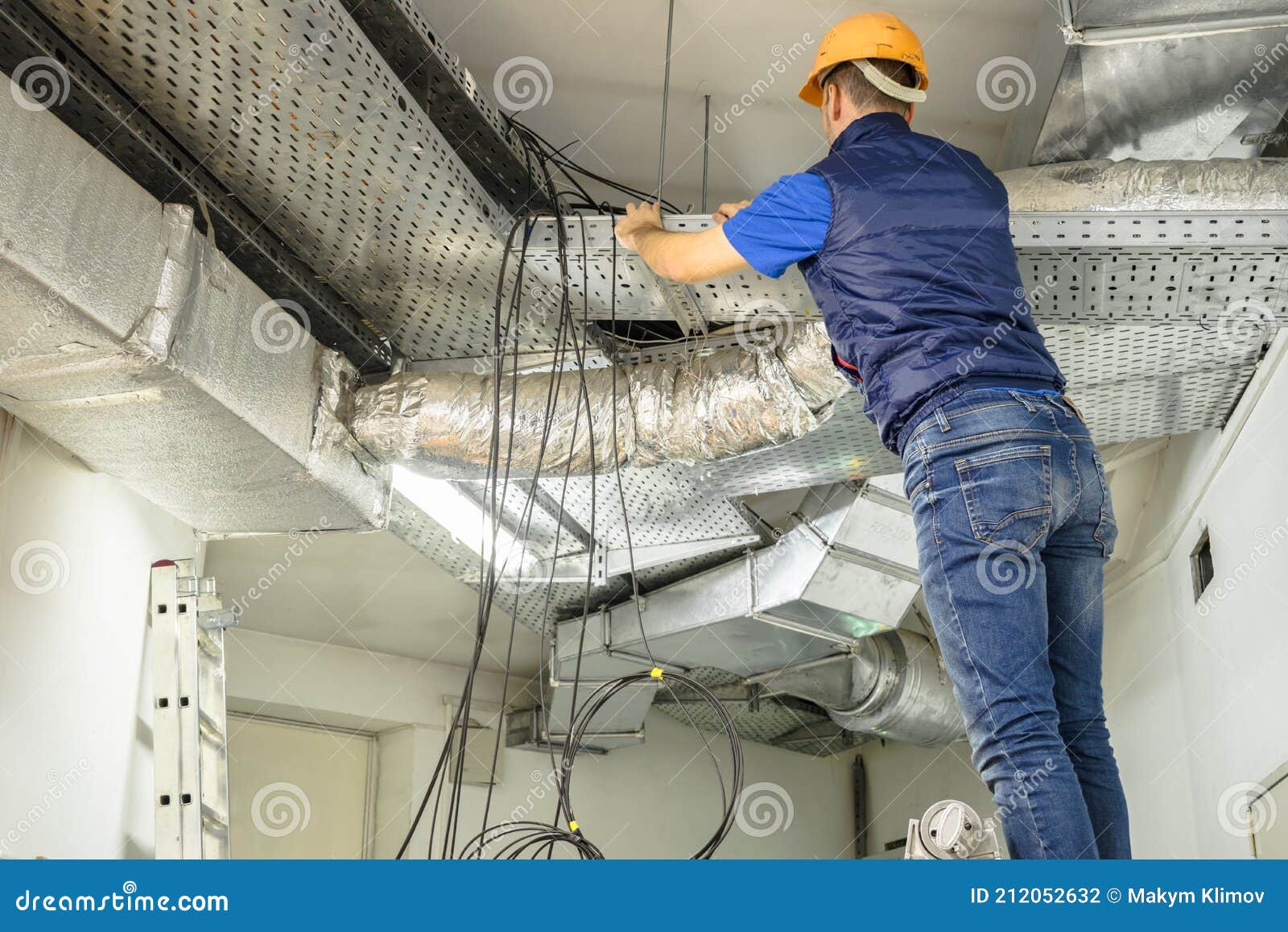 A Man Works with Wires Near a False Ceiling. the Worker Does the Wiring ...