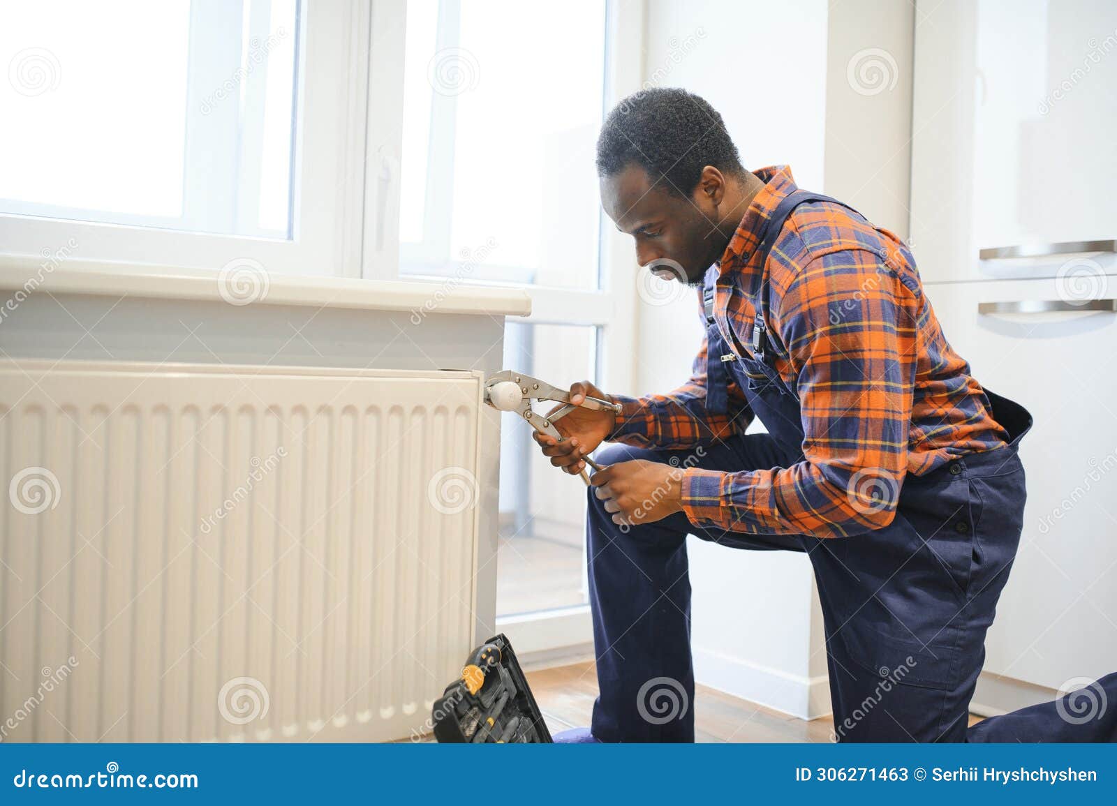 Man in Workwear Overalls Using Tools while Installing or Repairing ...