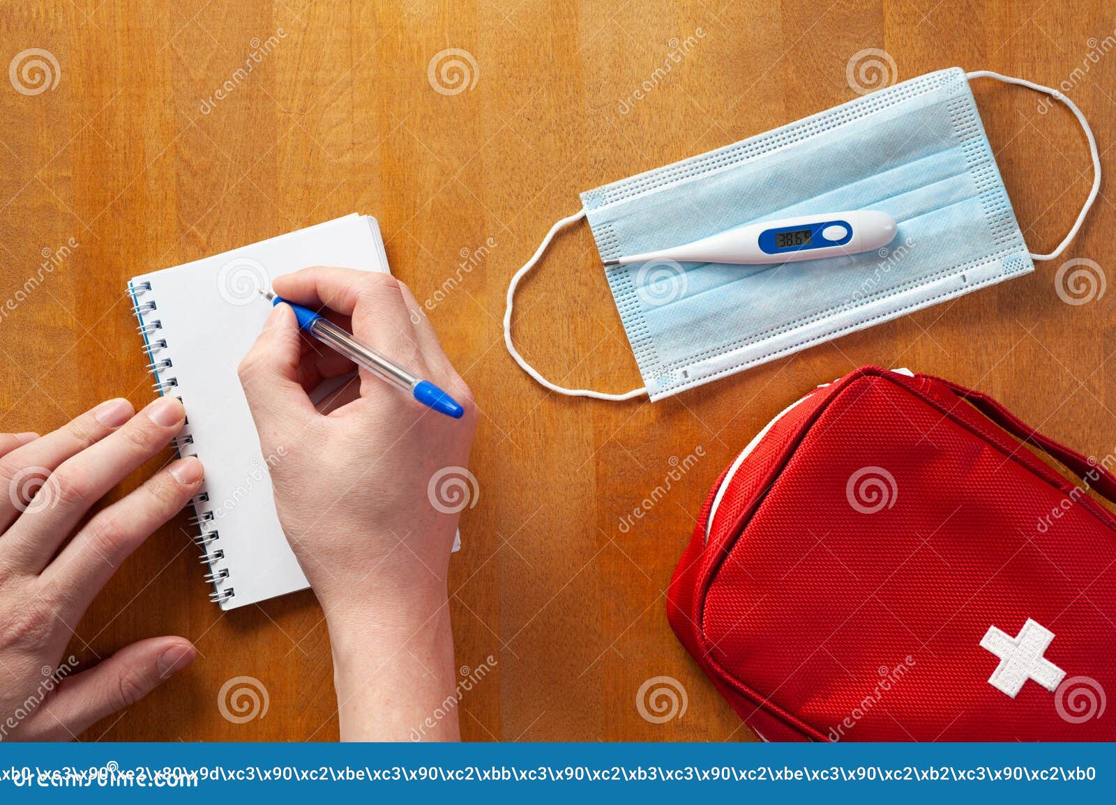 A Man Writes in a Notebook Next To a First Aid Kit a Mask and a ...