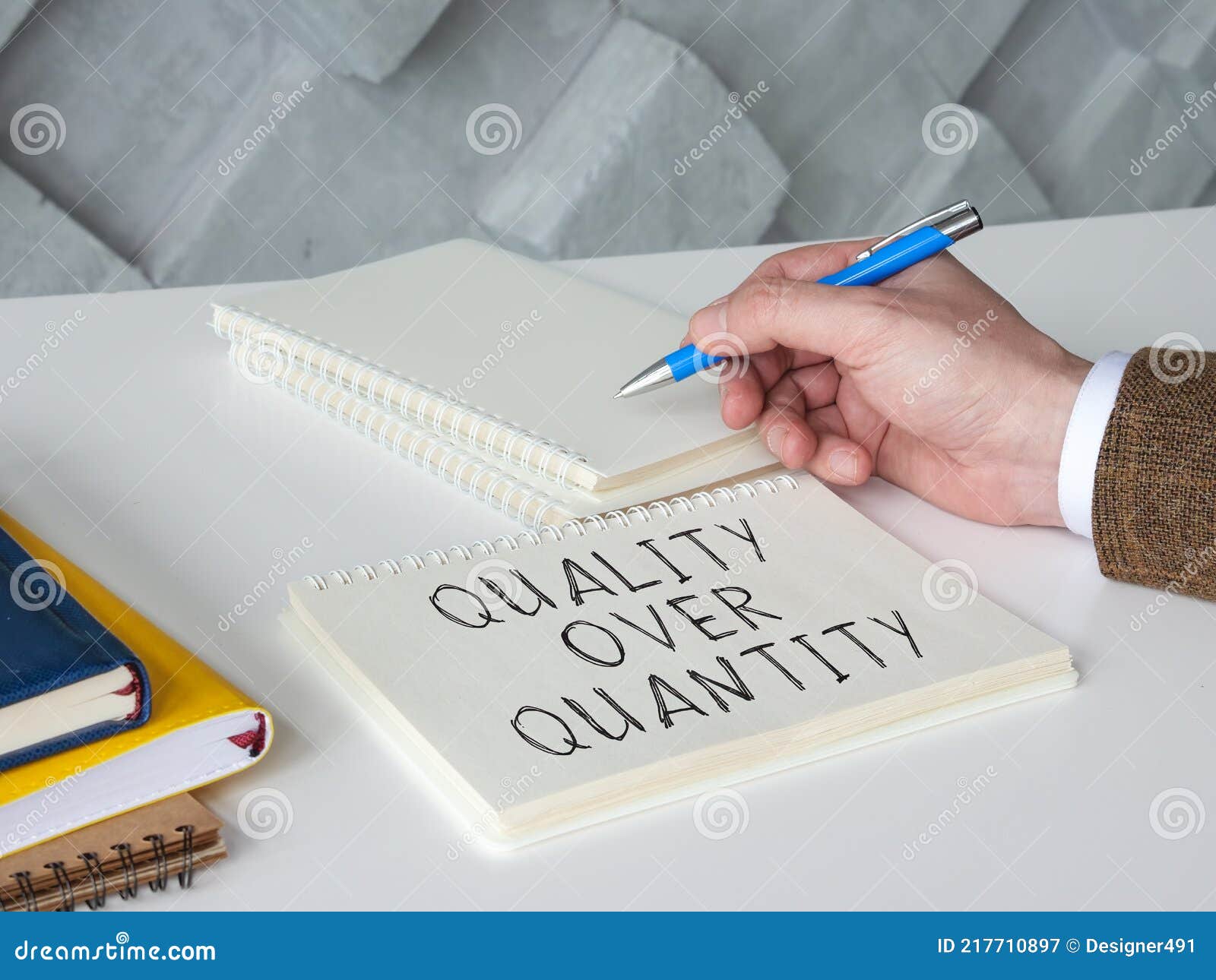 Man Writes Phrase Quality Over Quantity on a Page. Stock Image - Image ...