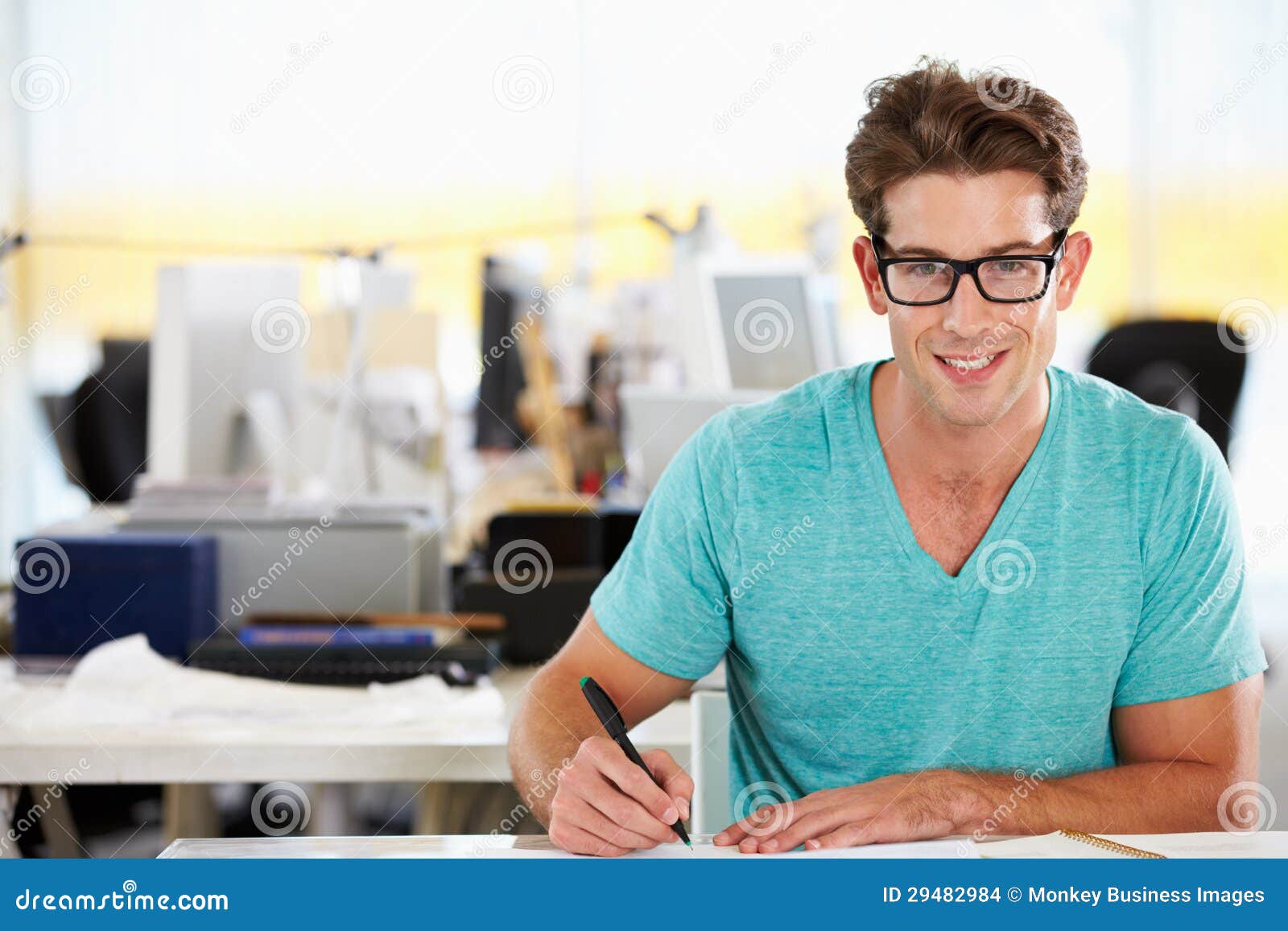Man Writing at Desk in Busy Creative Office Stock Photo - Image of male ...