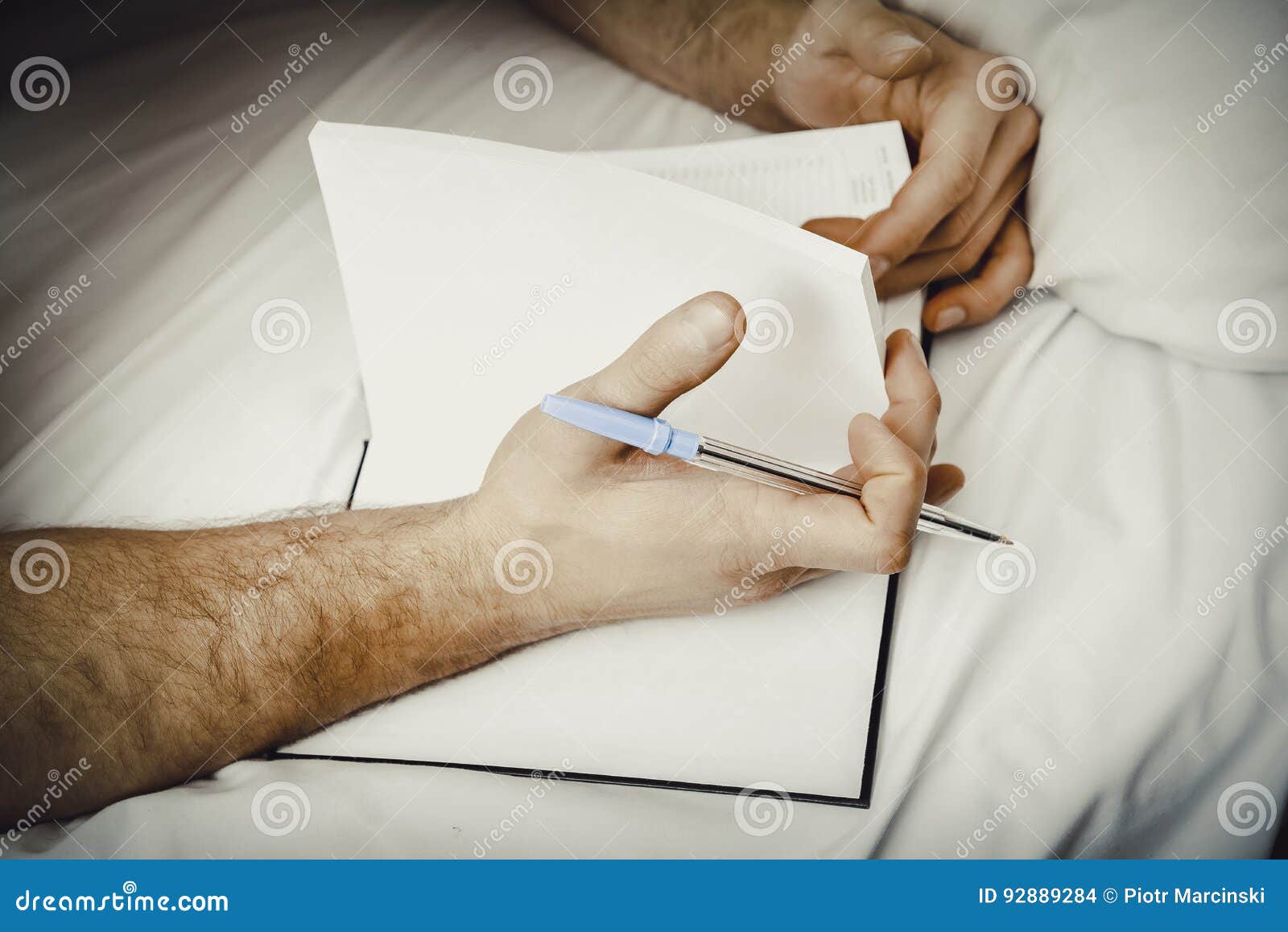 Man writing a note in bed. stock photo. Image of home - 92889284