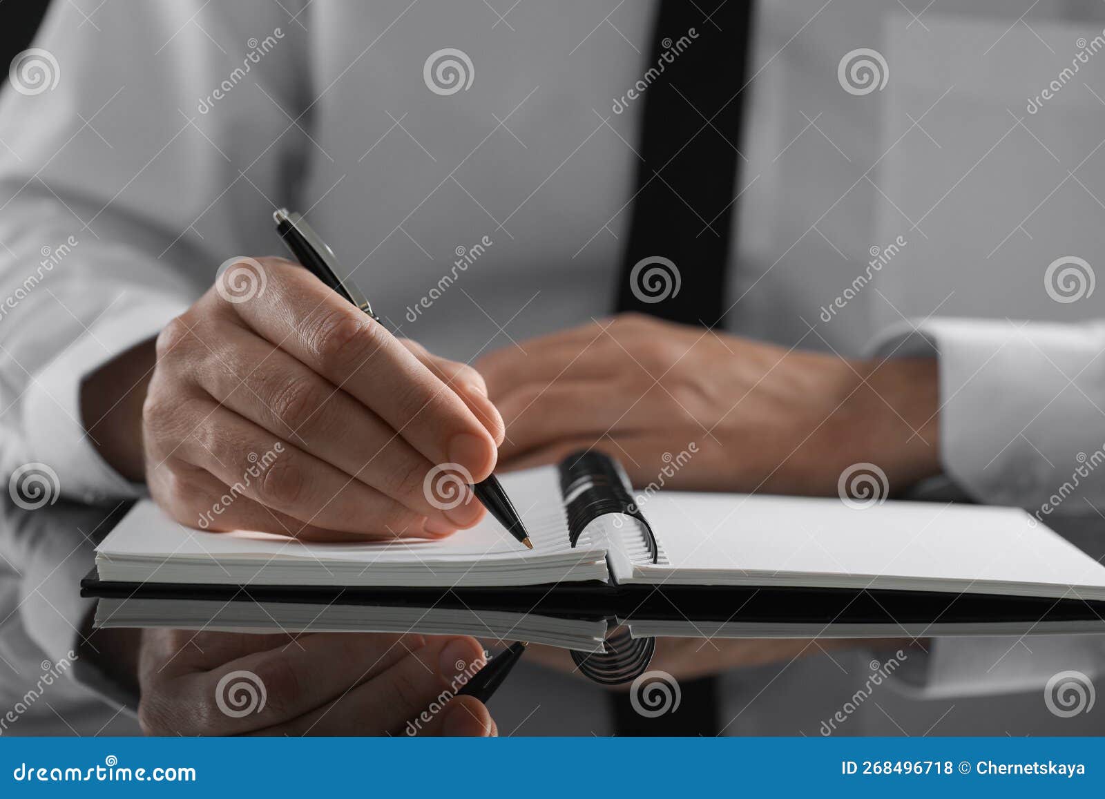 Man Writing in Notebook at Black Table, Closeup. Space for Text Stock ...