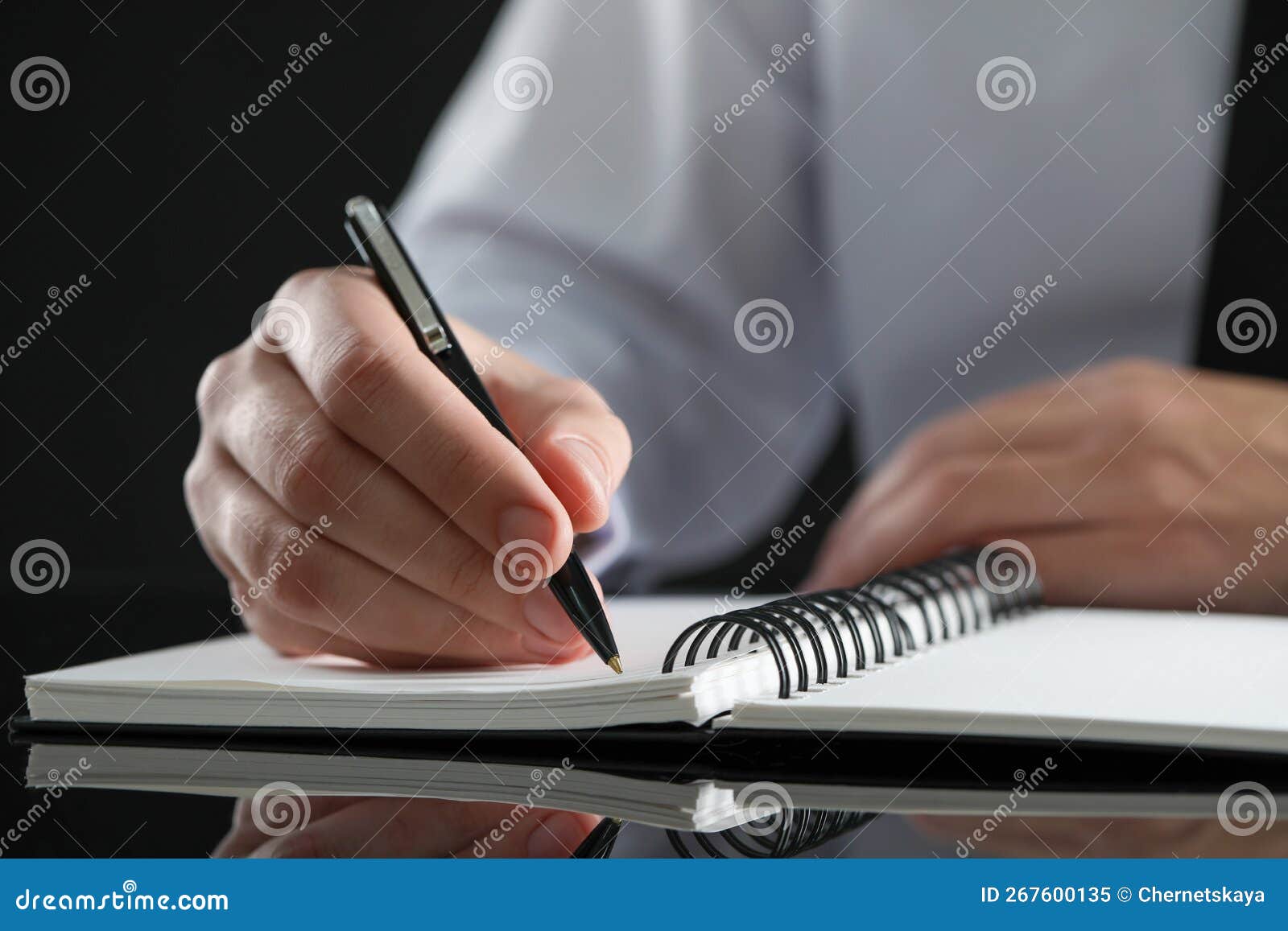Man Writing in Notebook at Black Table, Closeup. Space for Text Stock ...
