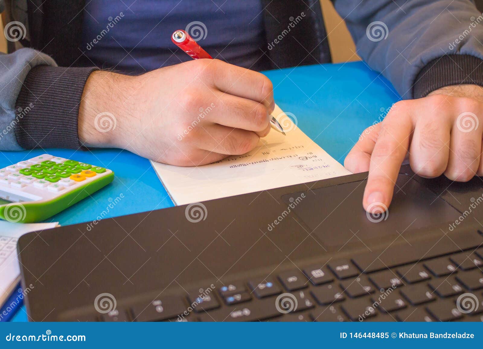 Man Writing Notes from Computer on Wooden Table. Man Hand with Pen ...