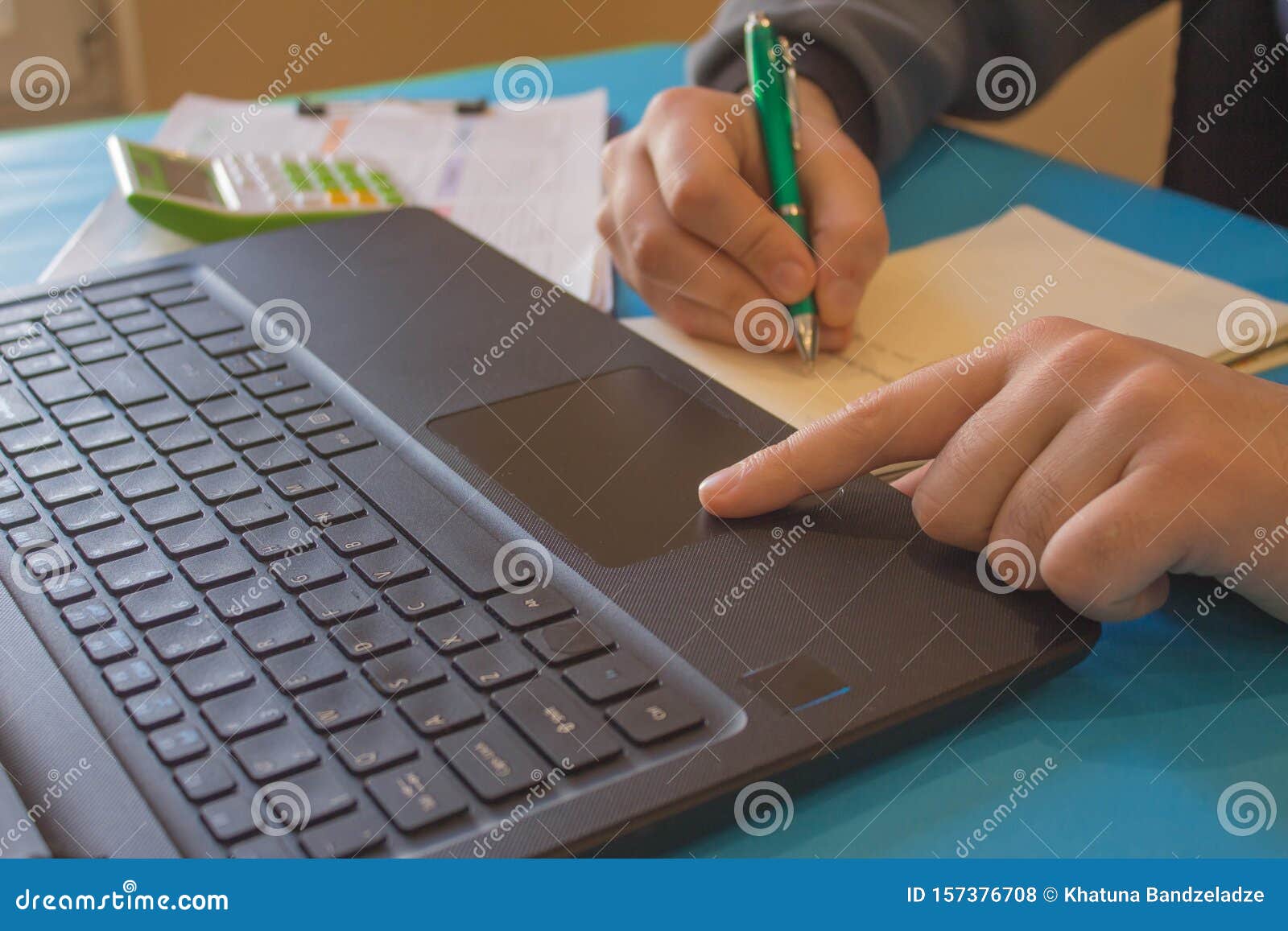 Man Writing Notes from Computer on Wooden Table. Man Hand with Pen ...