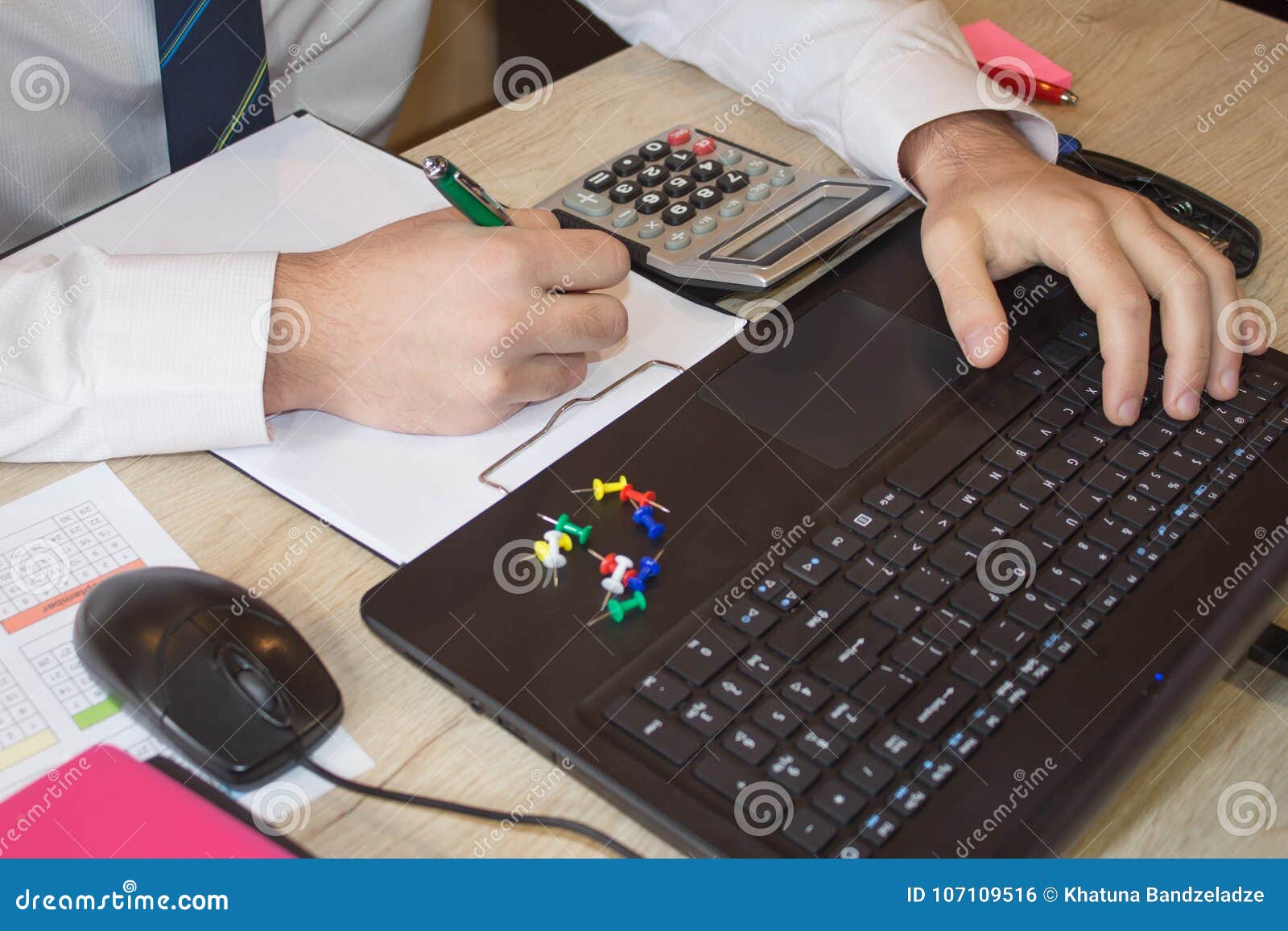Man Writing Notes from Computer on Wooden Table. Man Hand with Pen ...