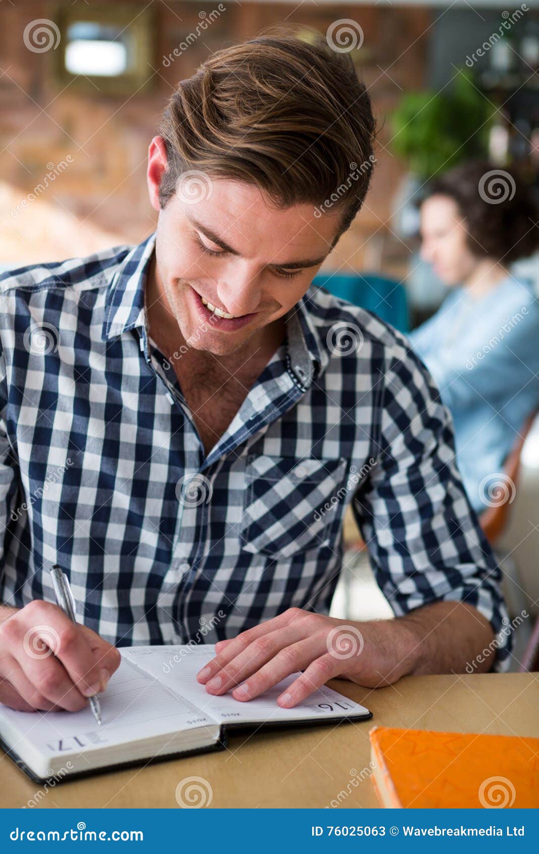 Man Writing Notes in Diary in Coffee Shop Stock Image - Image of people ...