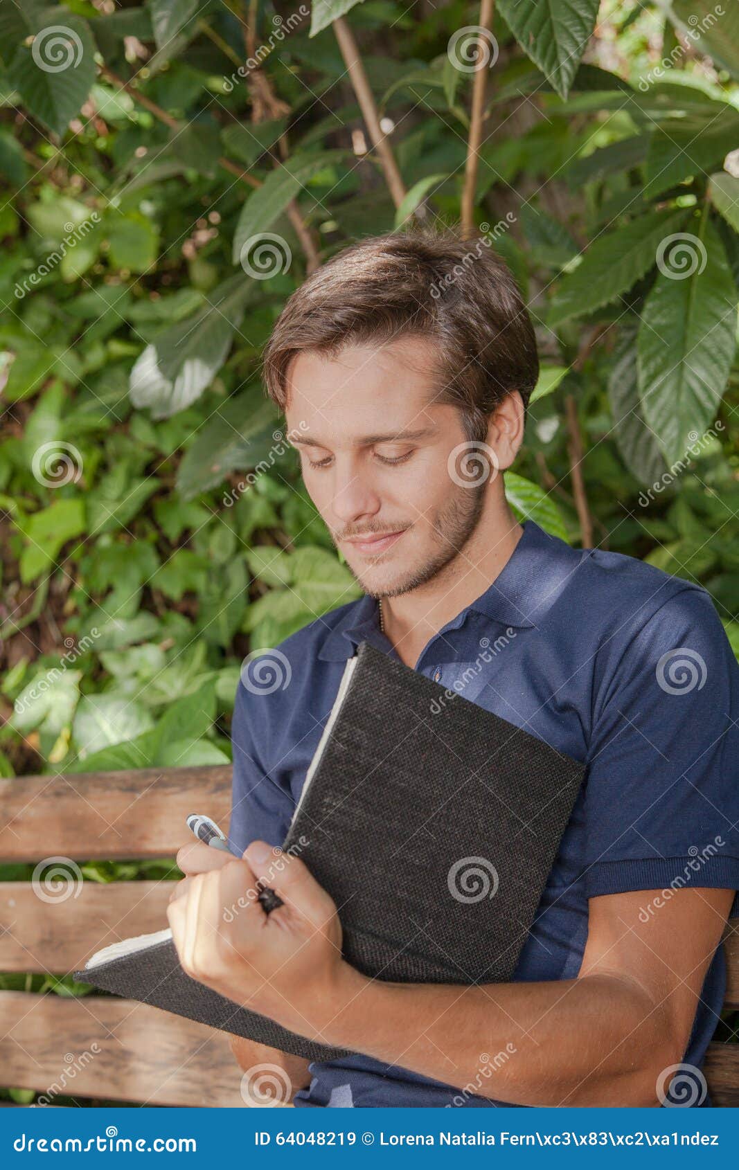 Man writing in the park stock image. Image of sitting - 64048219