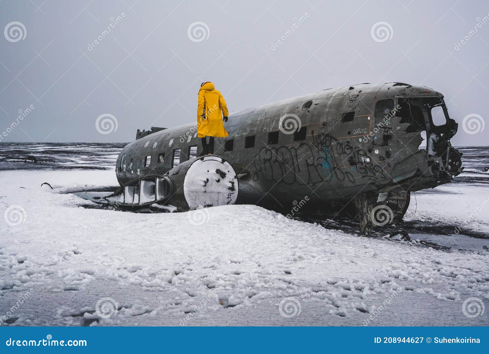 A Man in a Yellow Raincoat Stands at the Site of a Plane Crash in ...