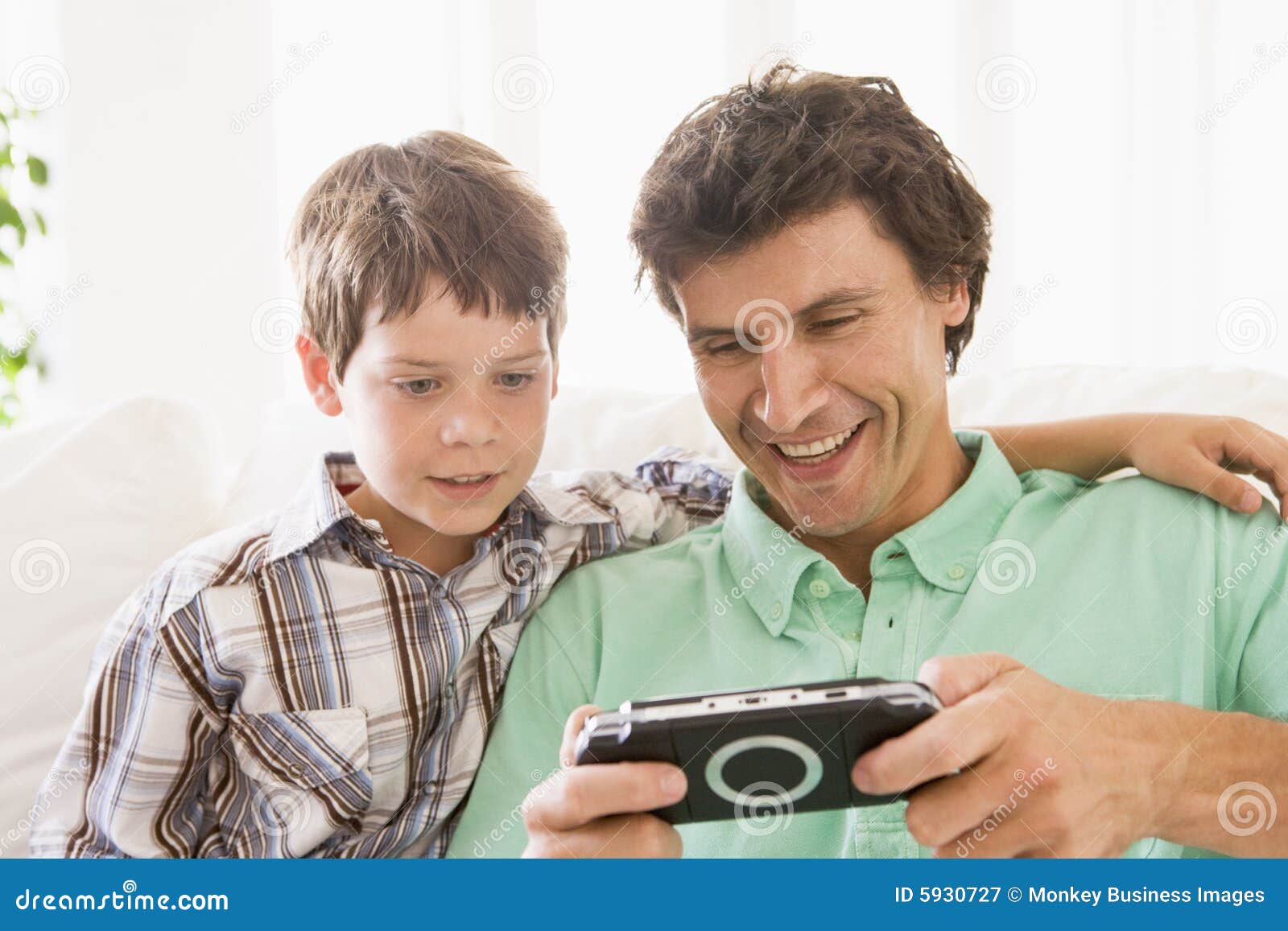 Man and Young Boy with Handheld Game Stock Image - Image of gaming ...