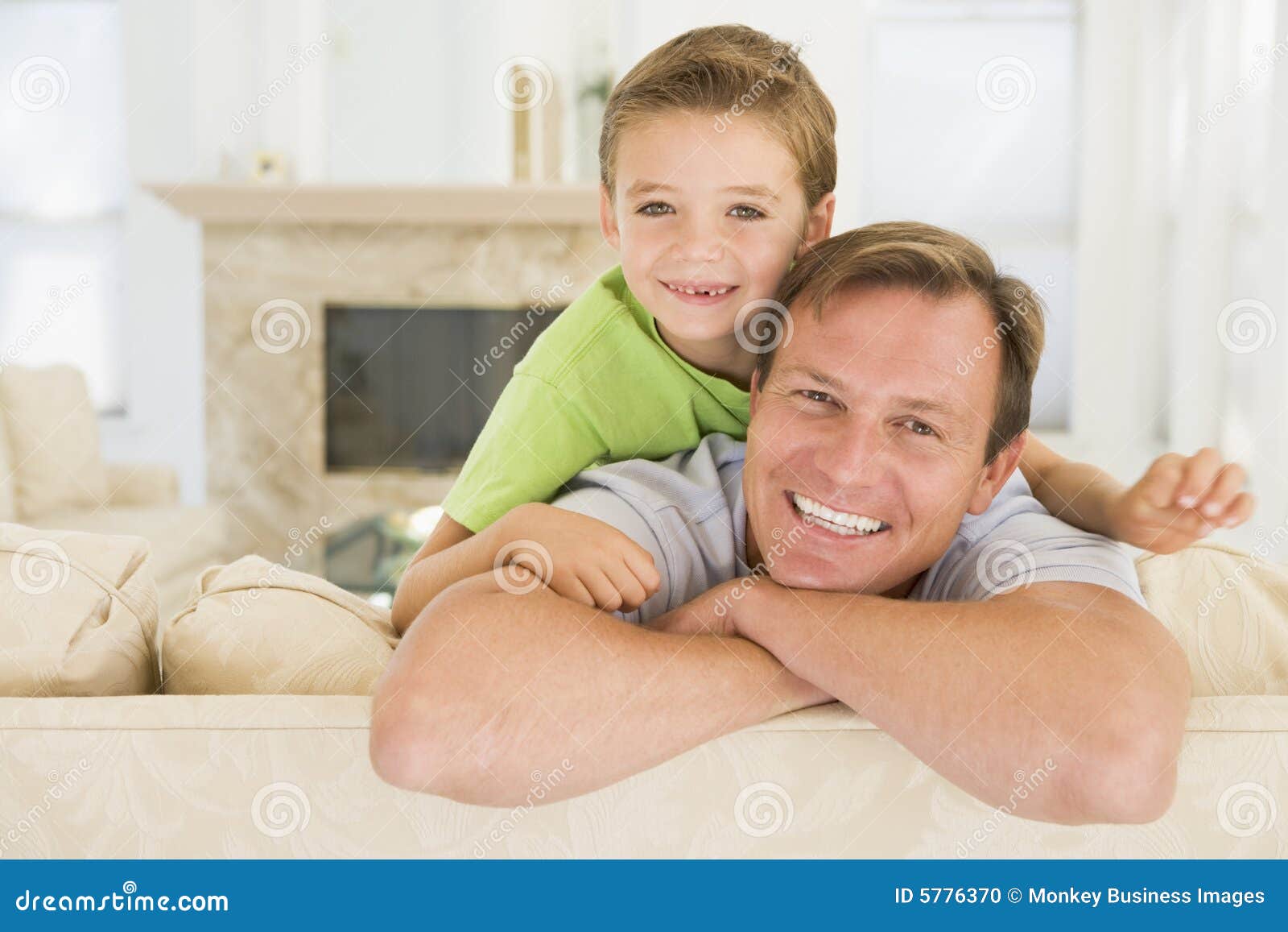 Man and Young Boy Sitting in Living Room Smiling Stock Photo - Image of ...