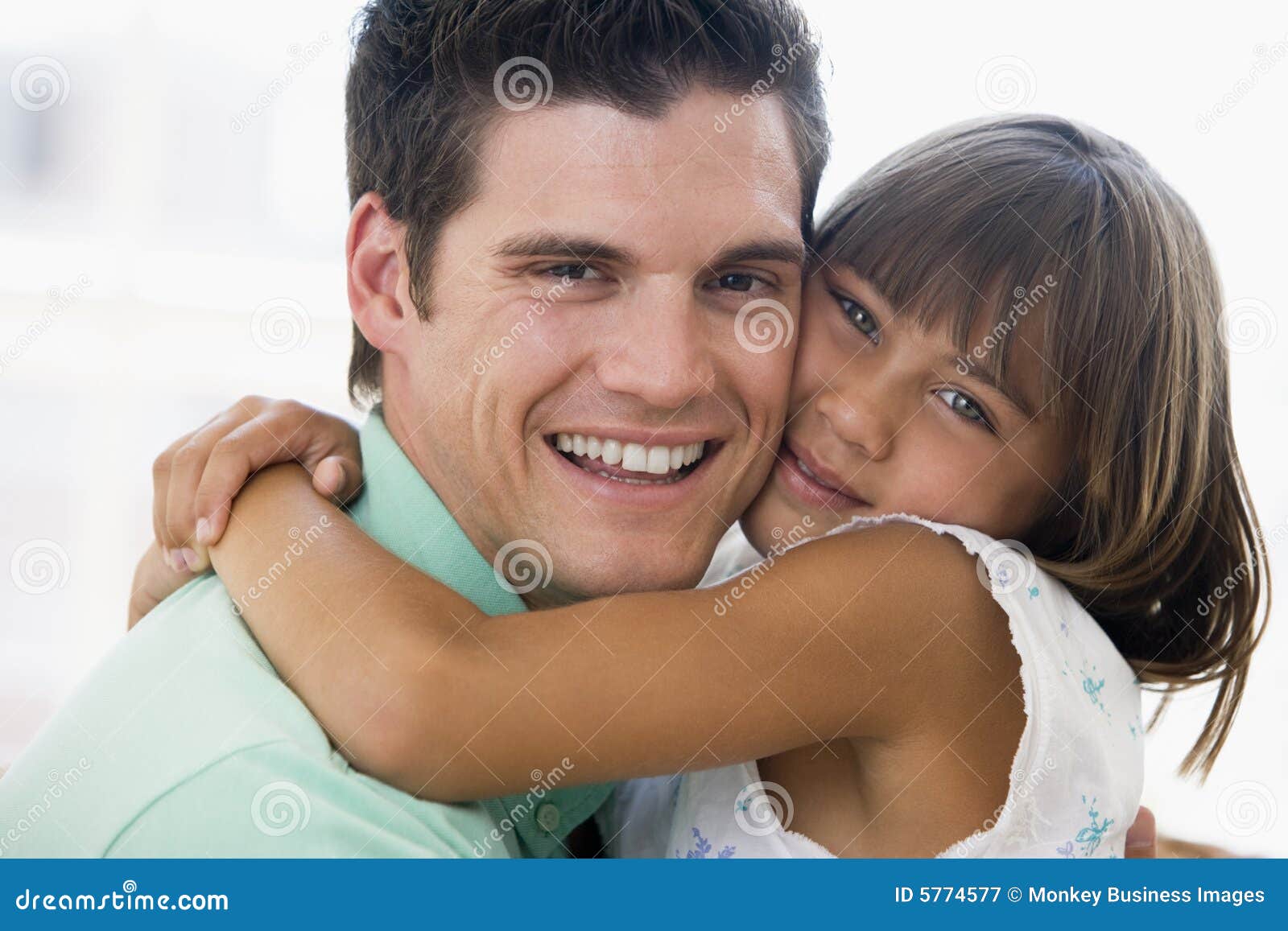 Hugging And Smiling Sisters Sitting On The Sofa Royalty-Free Stock ...